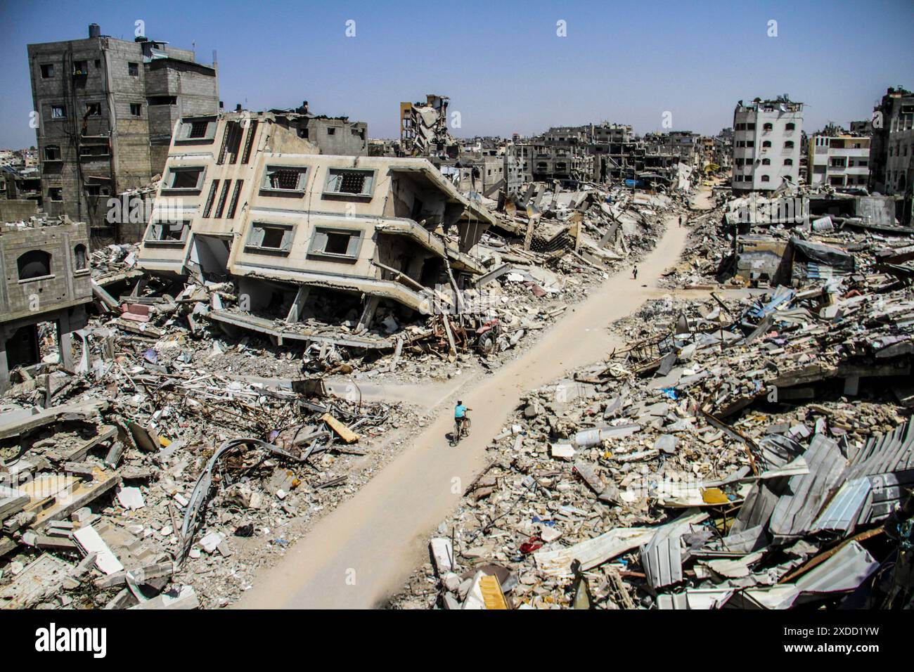 Gaza. 21st June, 2024. Palestinians walk among the rubble in the town ...