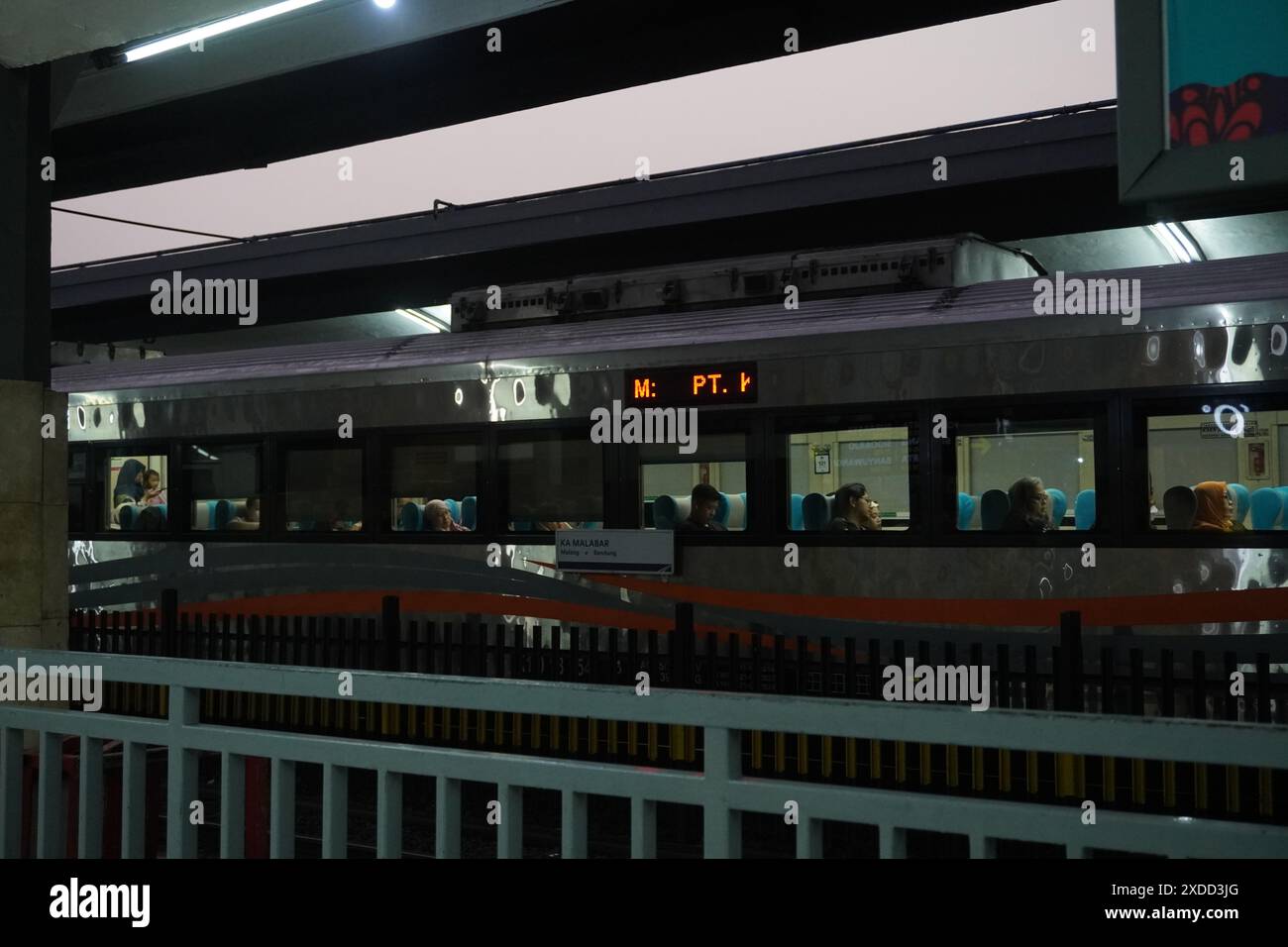 Passengers of a train who are in the train in the dark morning when the train stops at a station ...