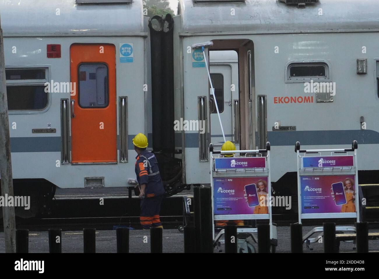Workers at a train station in Indonesia cleaning the train body in the ...