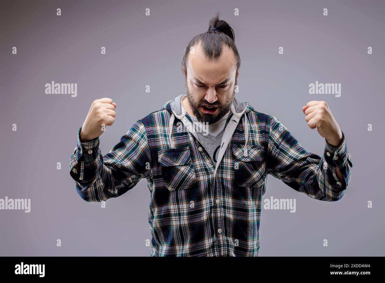 Bearded man with clenched fists expressing anger and frustration ...