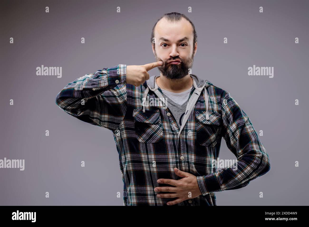 Bearded man playfully touching cheek, making funny face and puffing ...
