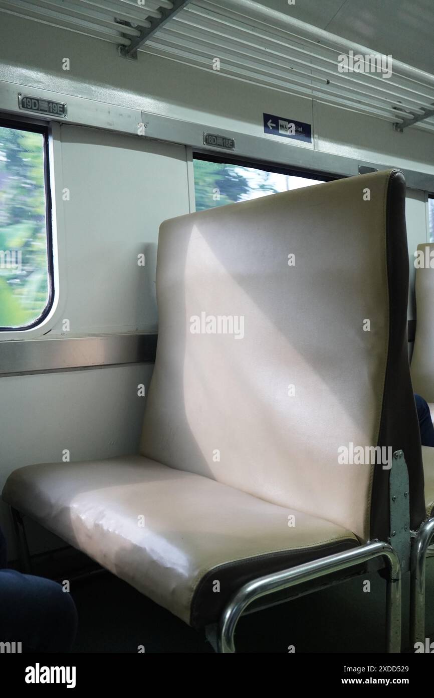 Economy class local Indonesian train seats with open windows in the ...