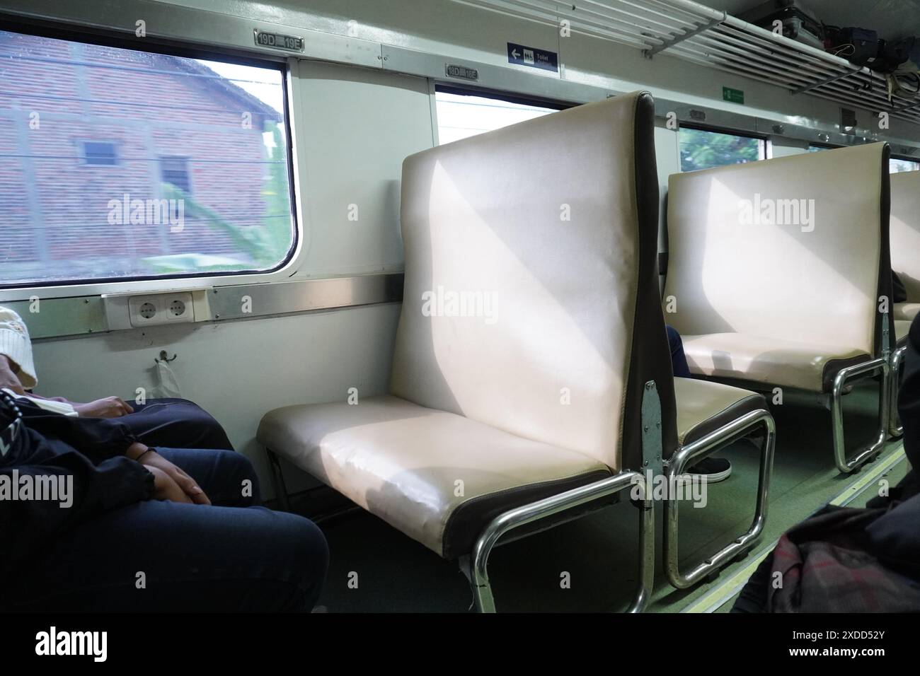 Economy class local Indonesian train seats with open windows in the ...