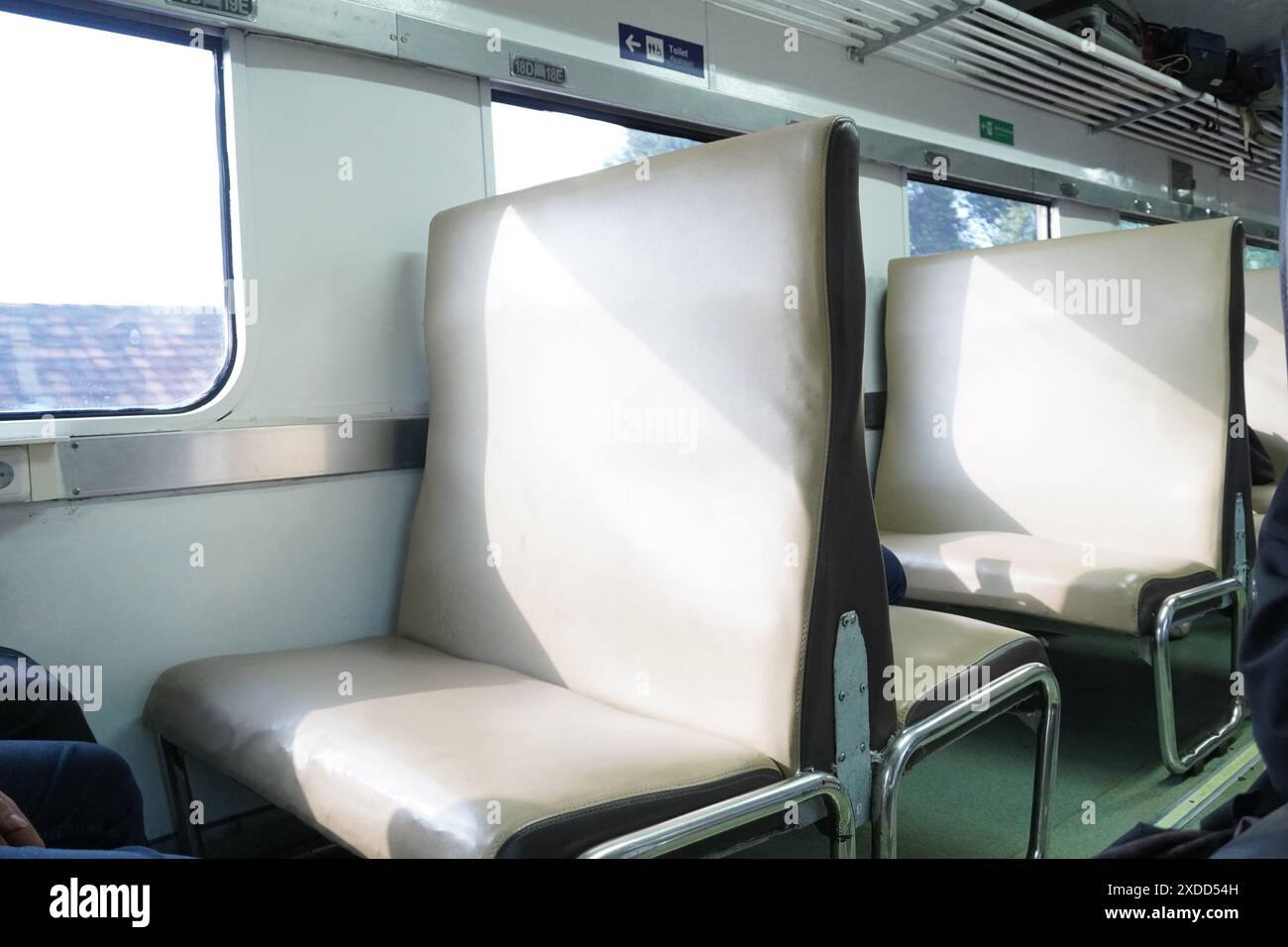 Economy class local Indonesian train seats with open windows in the ...