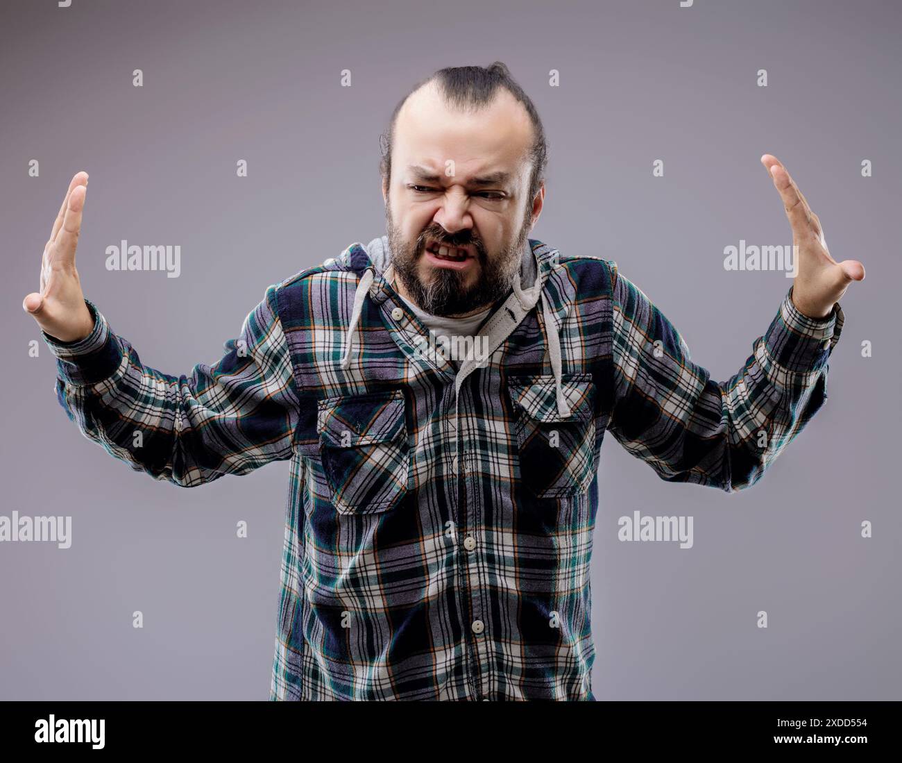 Bearded man is expressing frustration and anger while raising his hands ...