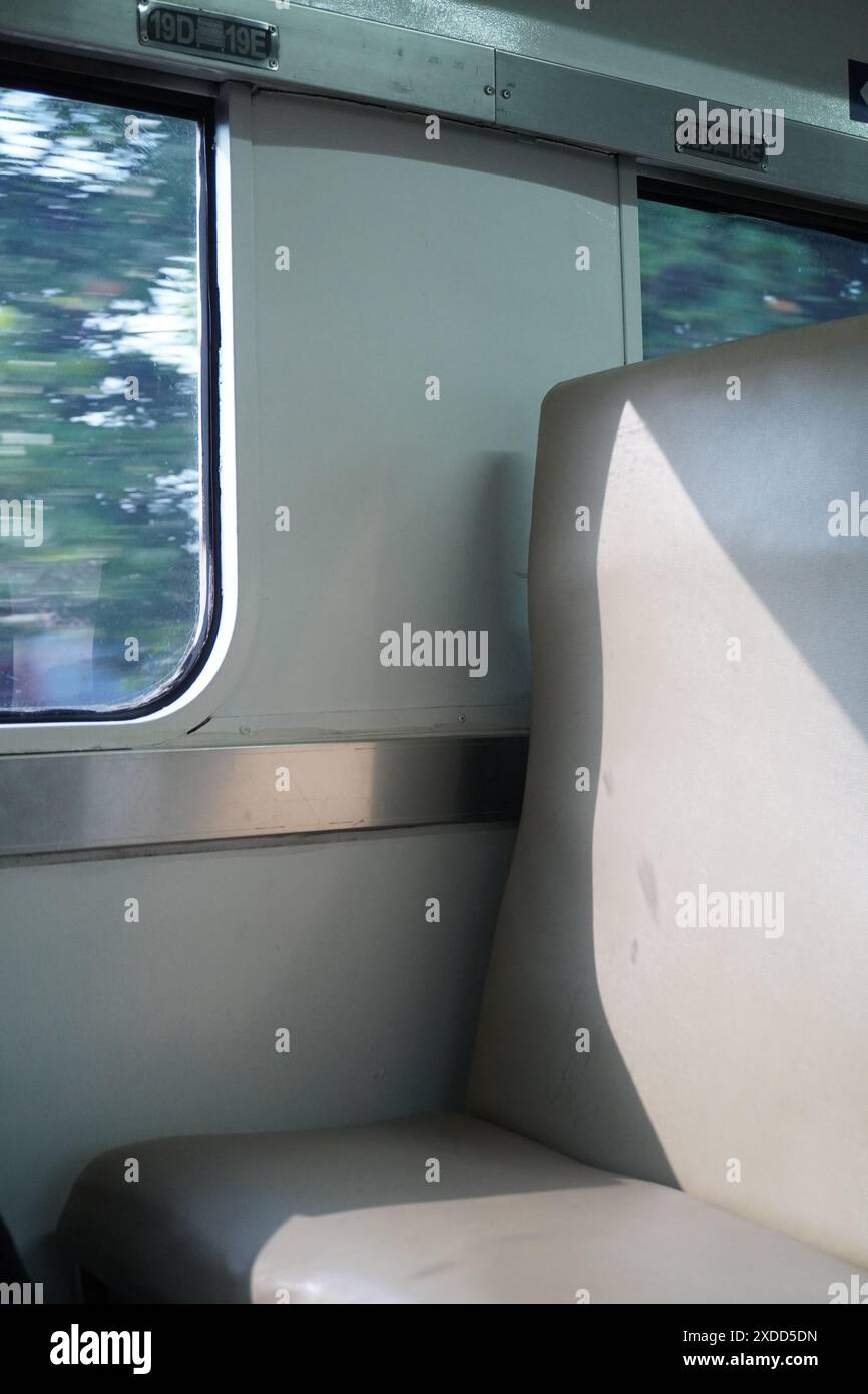 Economy class local Indonesian train seats with open windows in the ...