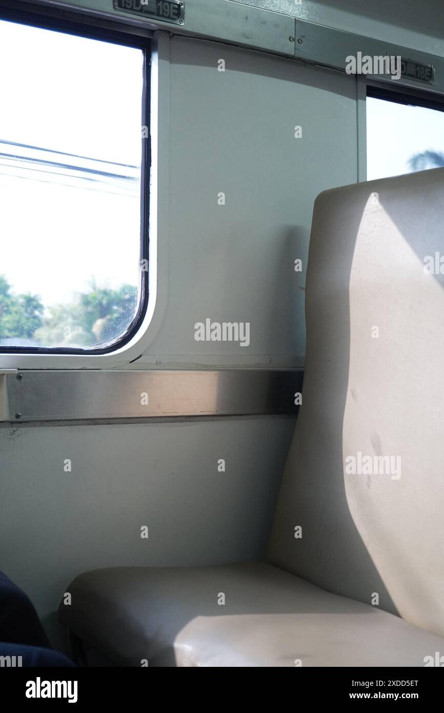 Economy class local Indonesian train seats with open windows in the ...