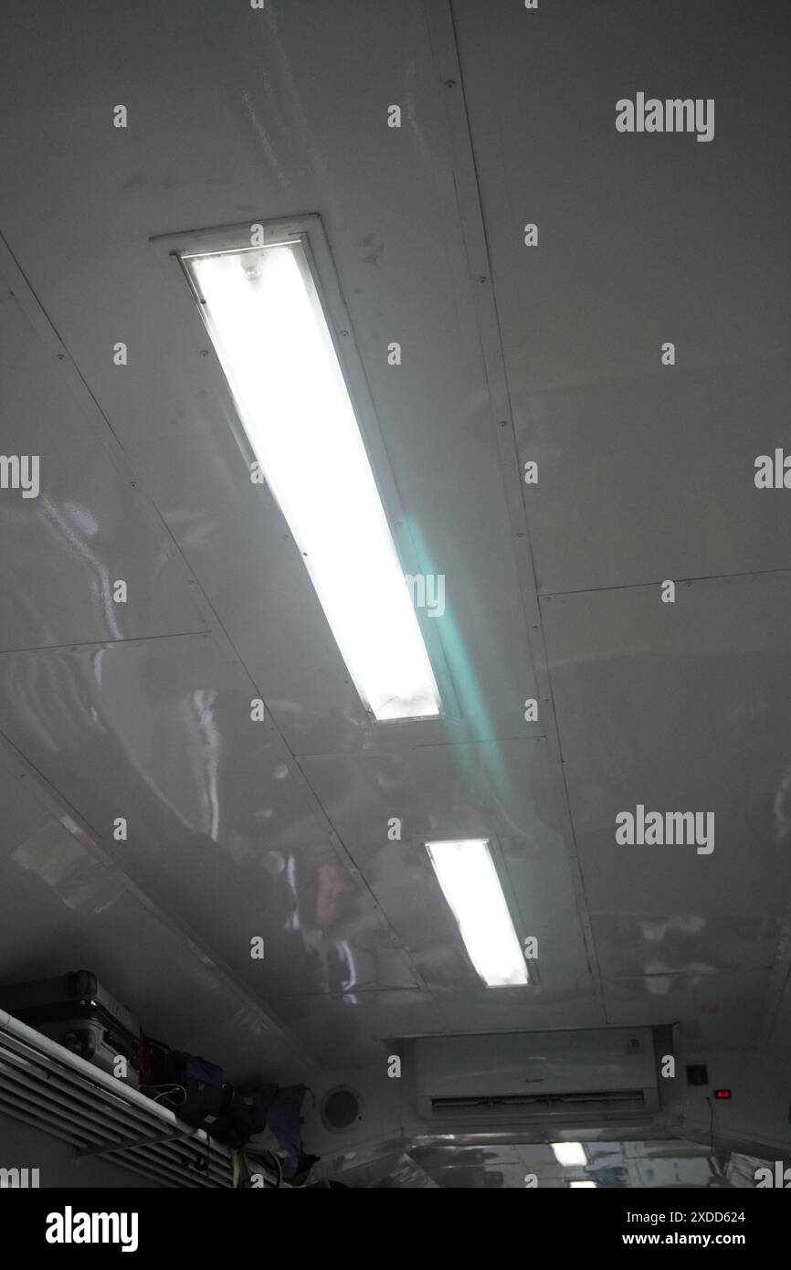 The lights in an economy class train in Indonesia are on in the morning ...