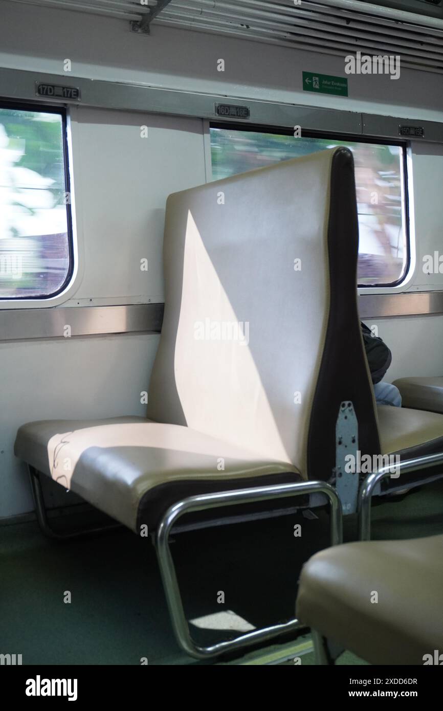 Economy class local Indonesian train seats with open windows in the ...