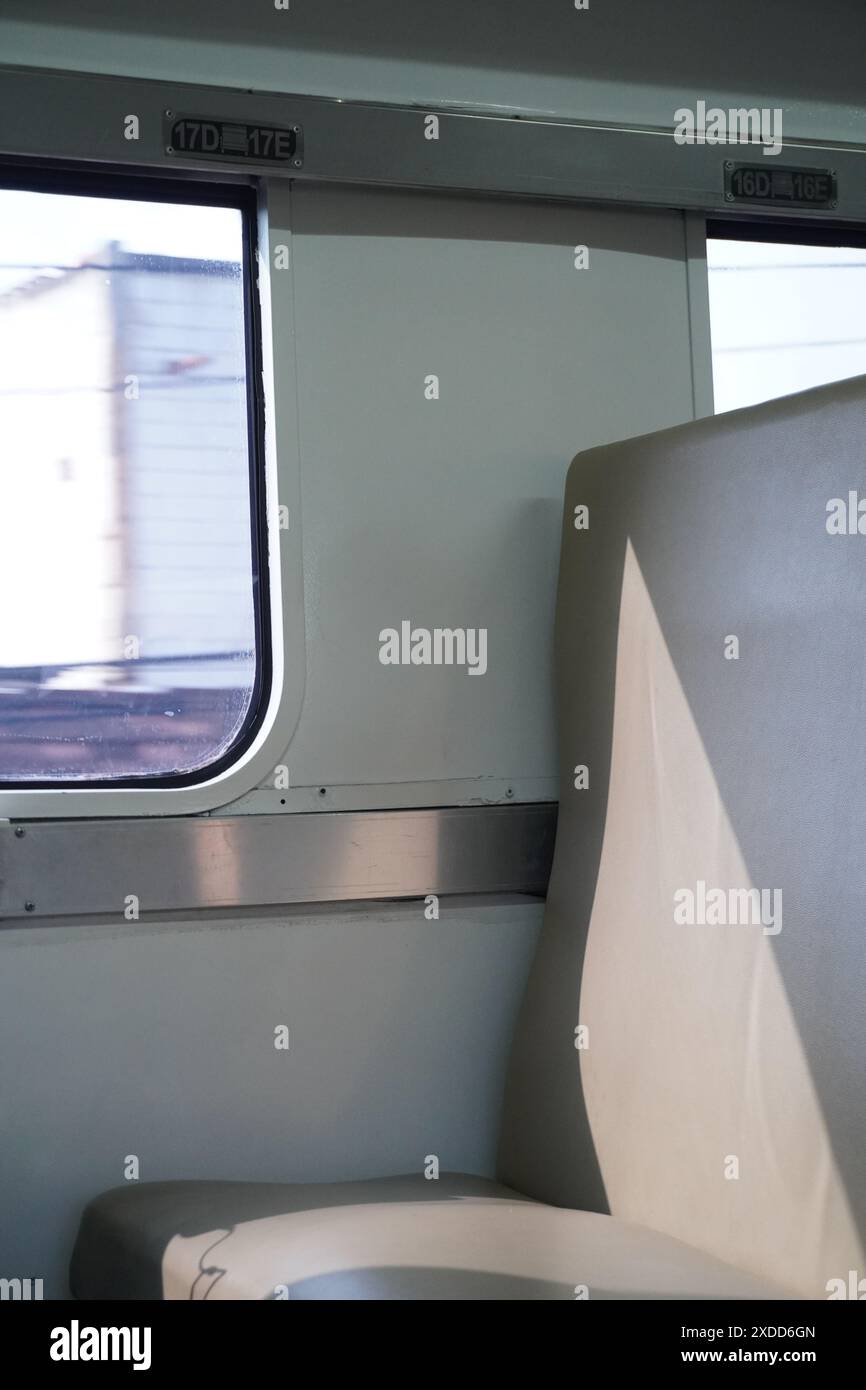 Economy class local Indonesian train seats with open windows in the ...