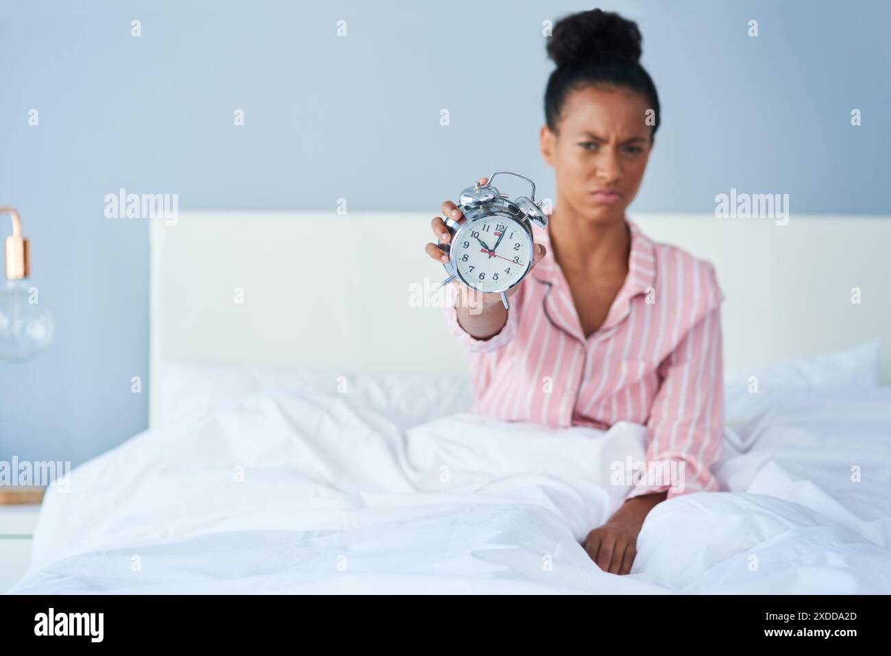 Alarm, woman and wake up in portrait while unhappy, annoyed and upset ...