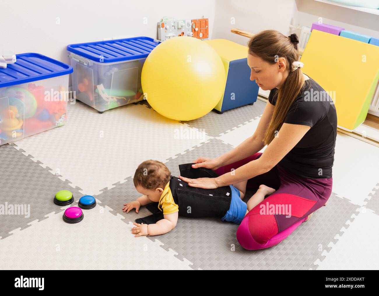 Physiotherapist putting orthopedic corset on child patient of medical ...