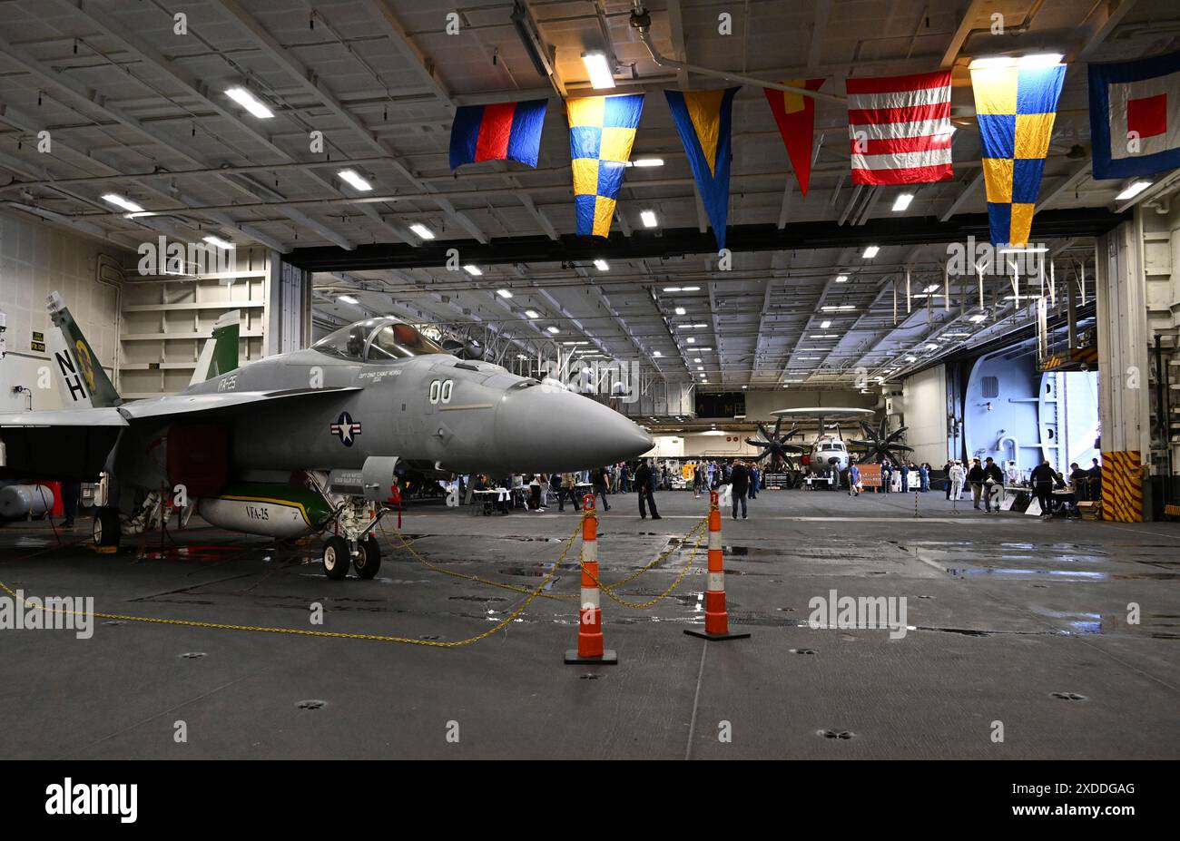 An F-18 fighter aircraft sits in the hanger of the Theodore Roosevelt ...