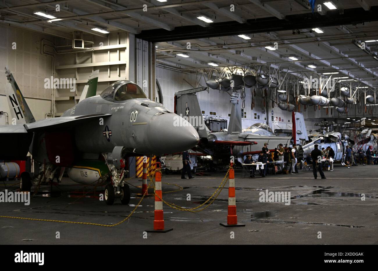 An F-18 fighter aircraft sits in the hanger of the Theodore Roosevelt ...