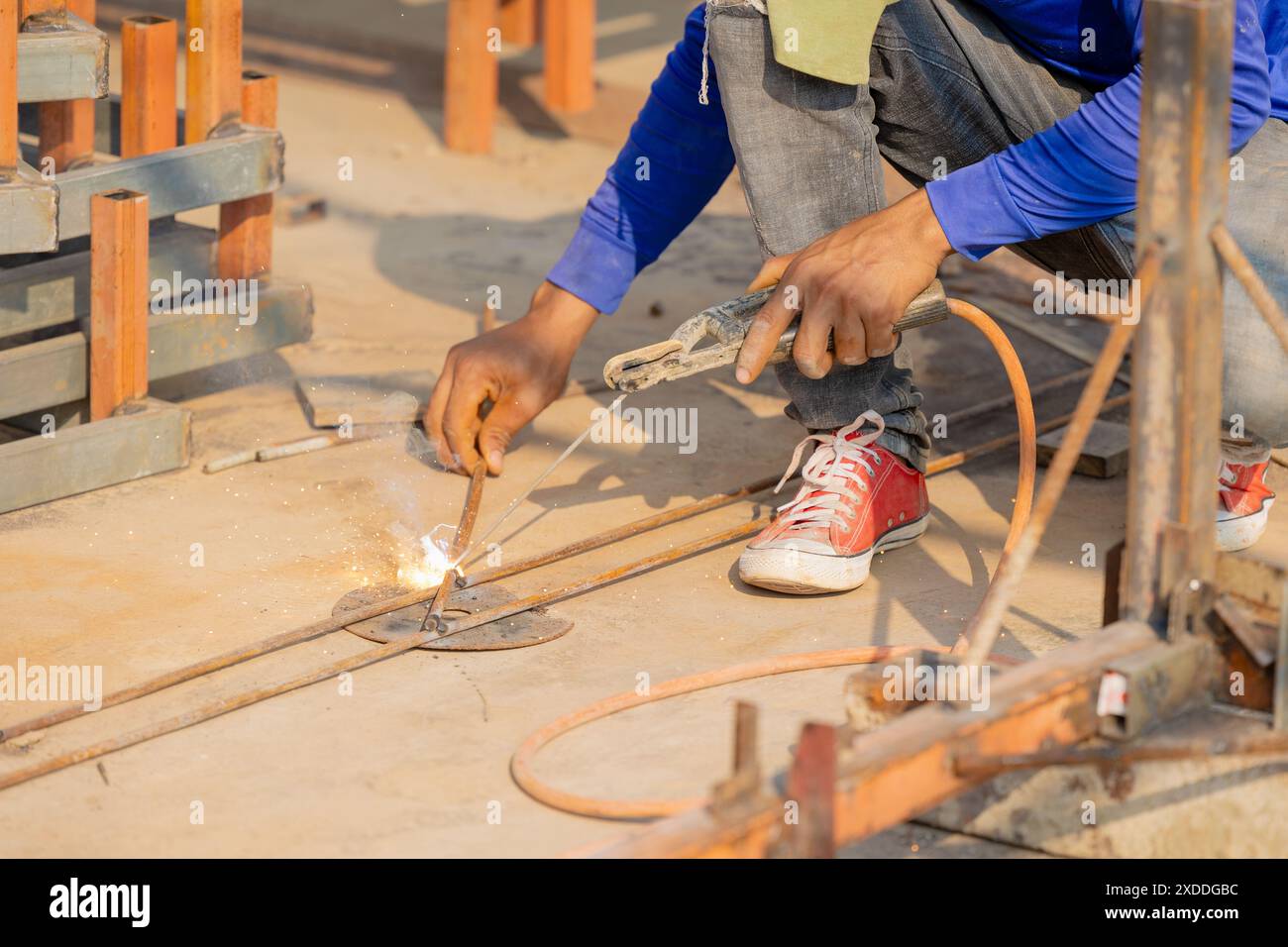 Industrial worker welding metal components on a construction site ...