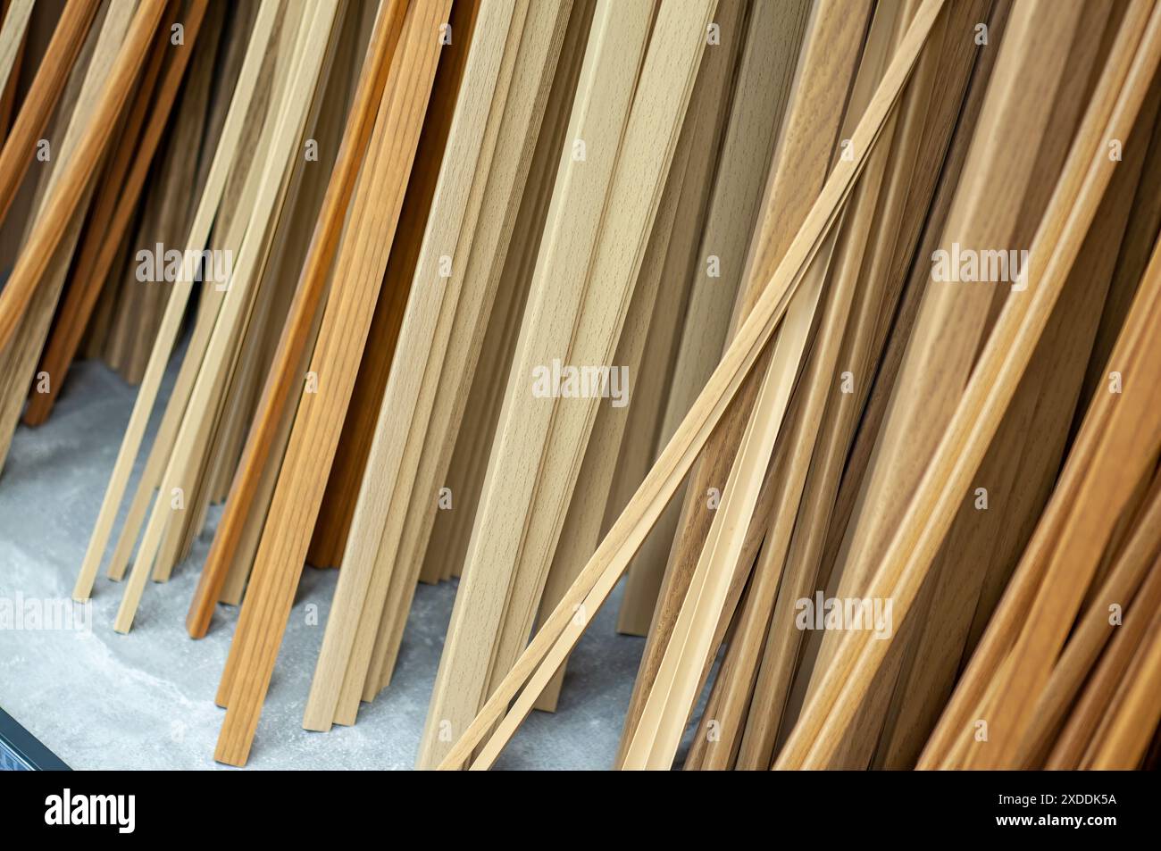 Close-up of various plastic baseboards in different wood-like finishes ...