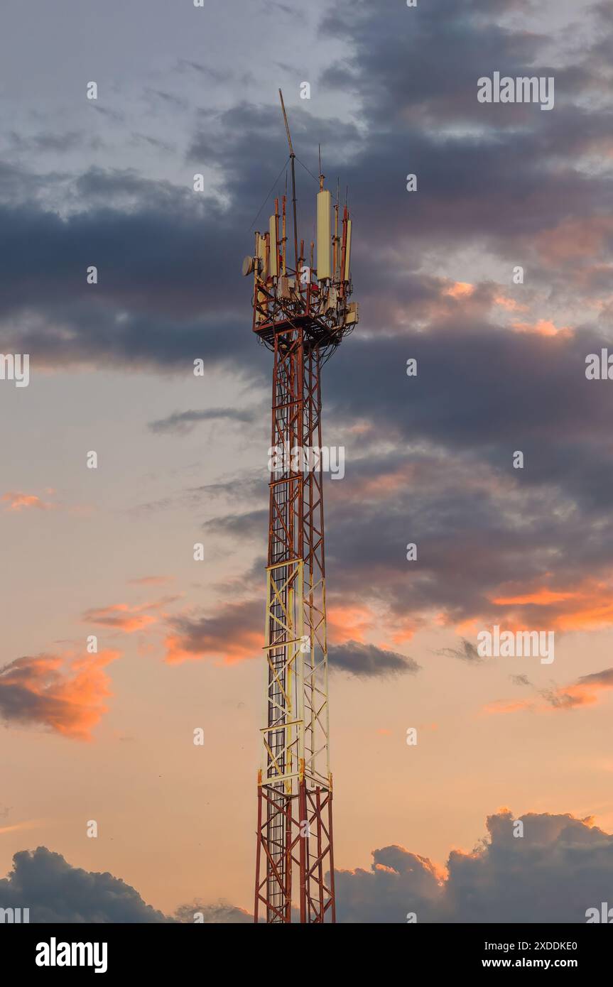 Telecommunication tower at sunset, with clouds adding depth to the ...