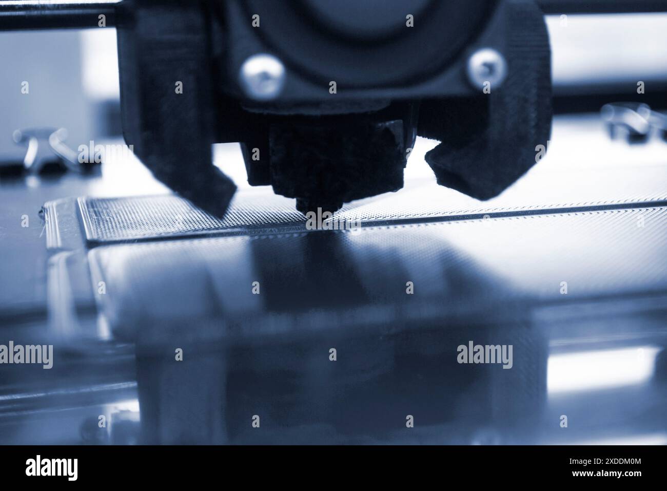 3D printer close up. A working 3D printer in process of printing object from molten plastic. 3D ...