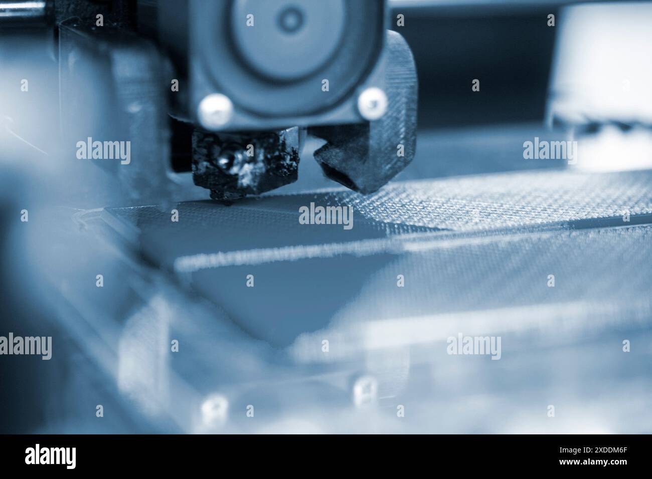 3D printer close up. A working 3D printer in process of printing object from molten plastic. 3D ...
