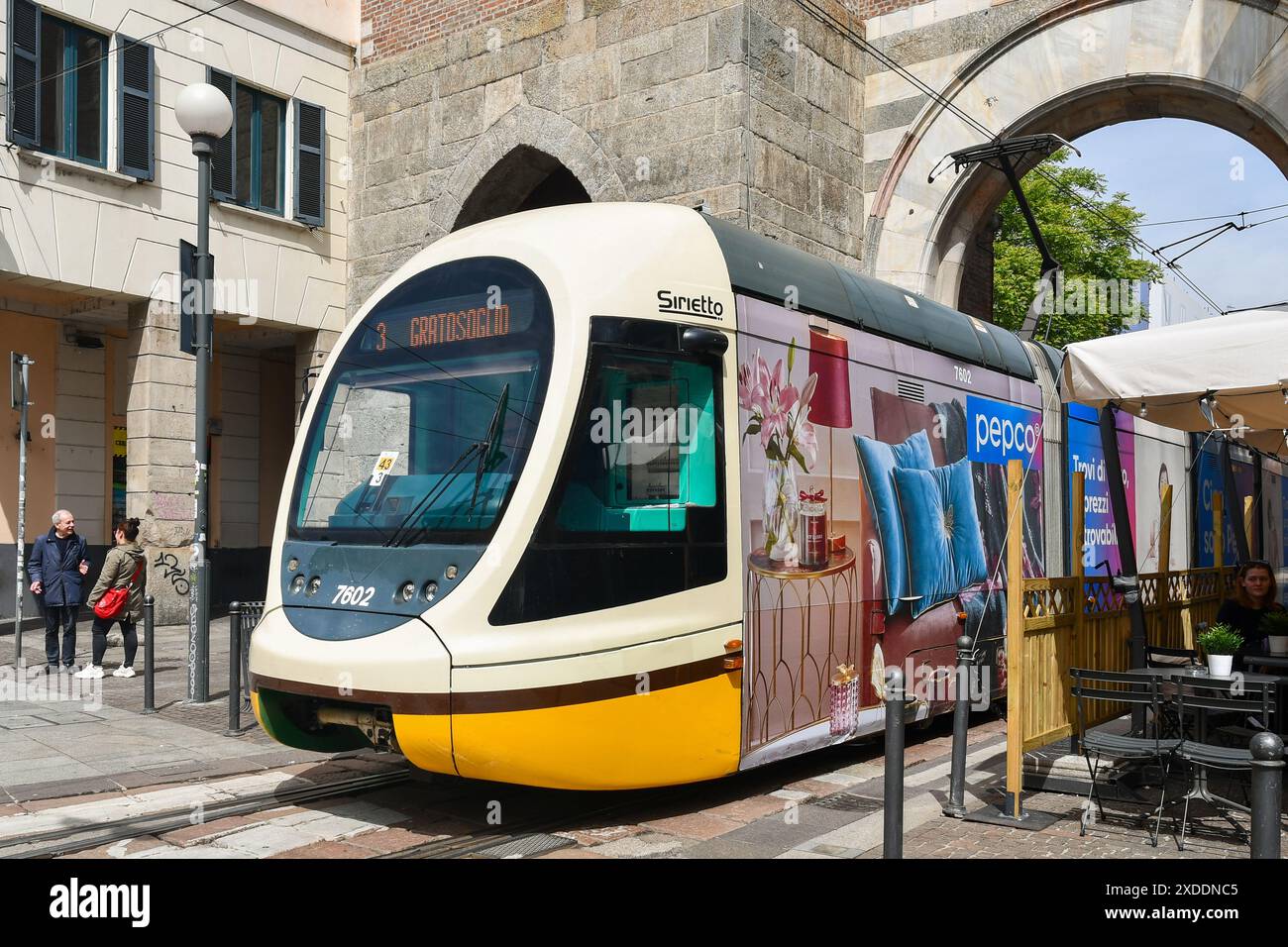Tram passing under the arch of the Medieval Porta Ticinese ancient city ...