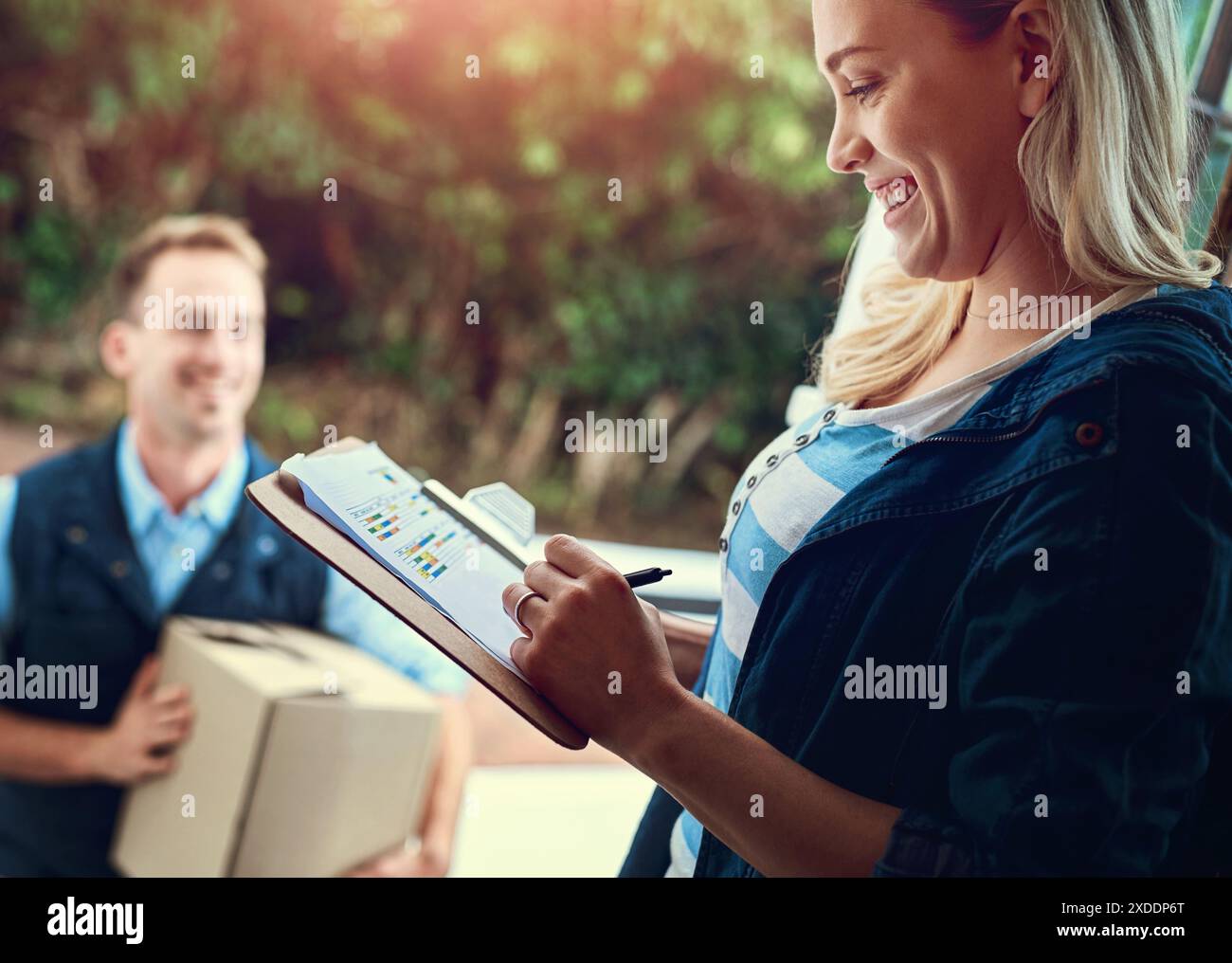 Woman, front door and signture with courier man for box with clipboard ...