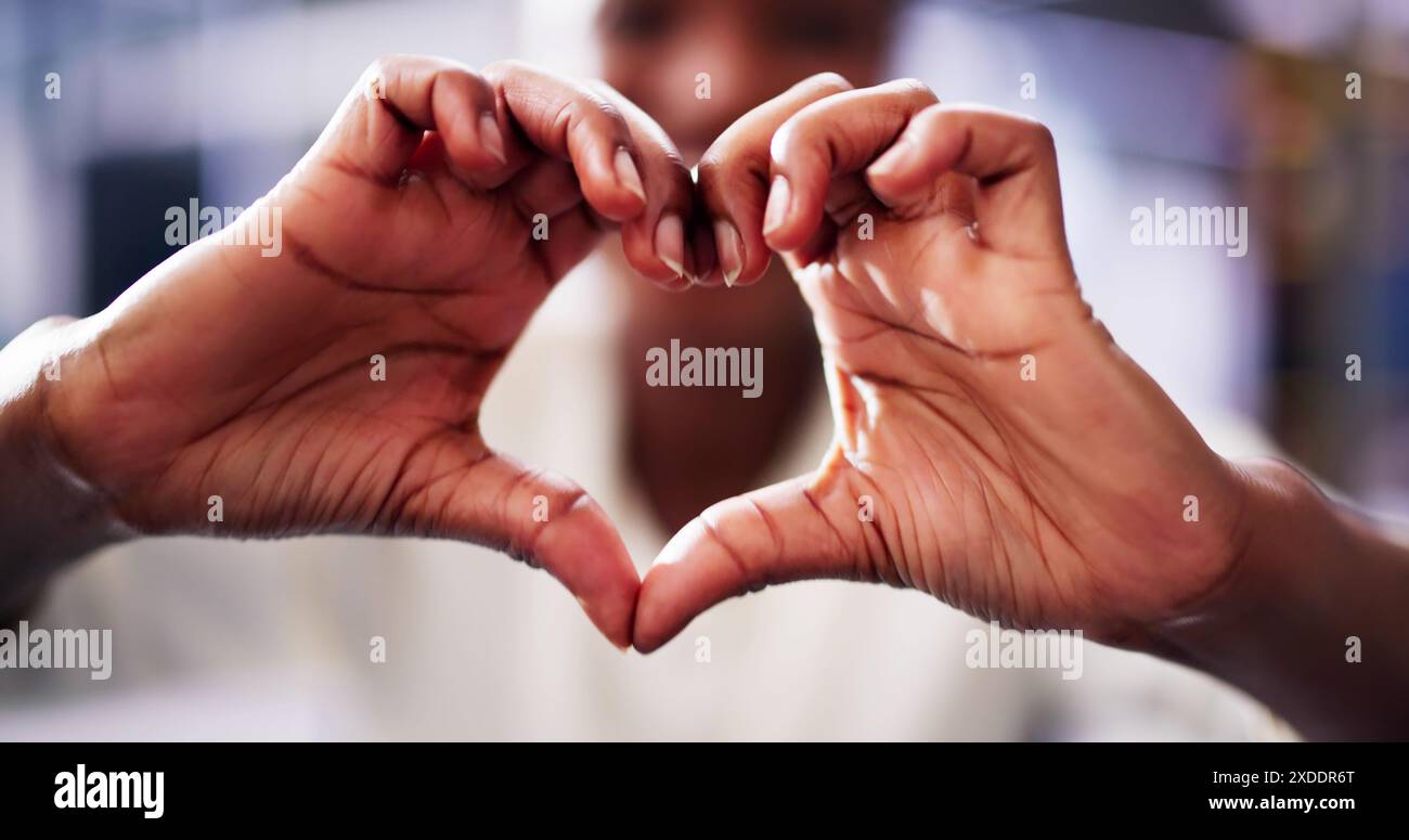 Senior African American woman making heart sign with hands, symbolizing ...