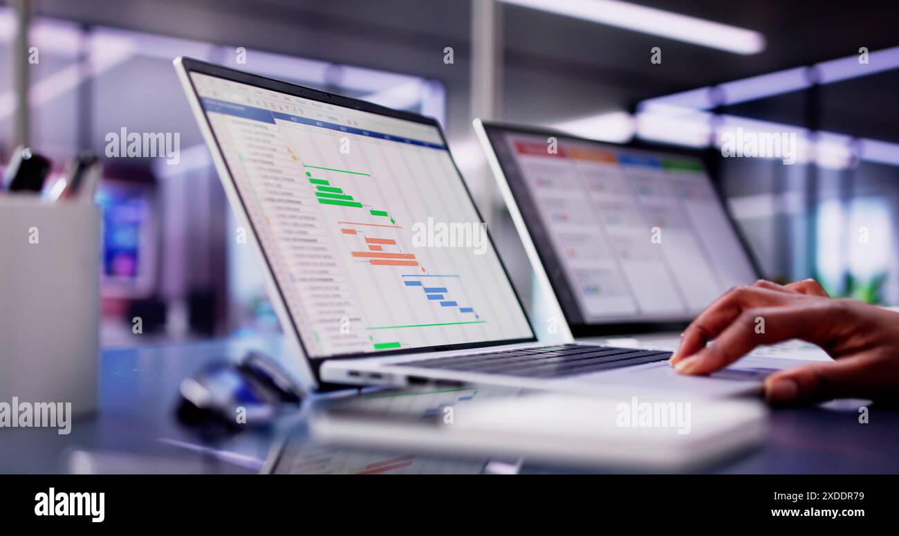 African American woman using laptop to manage multiple tasks and ...