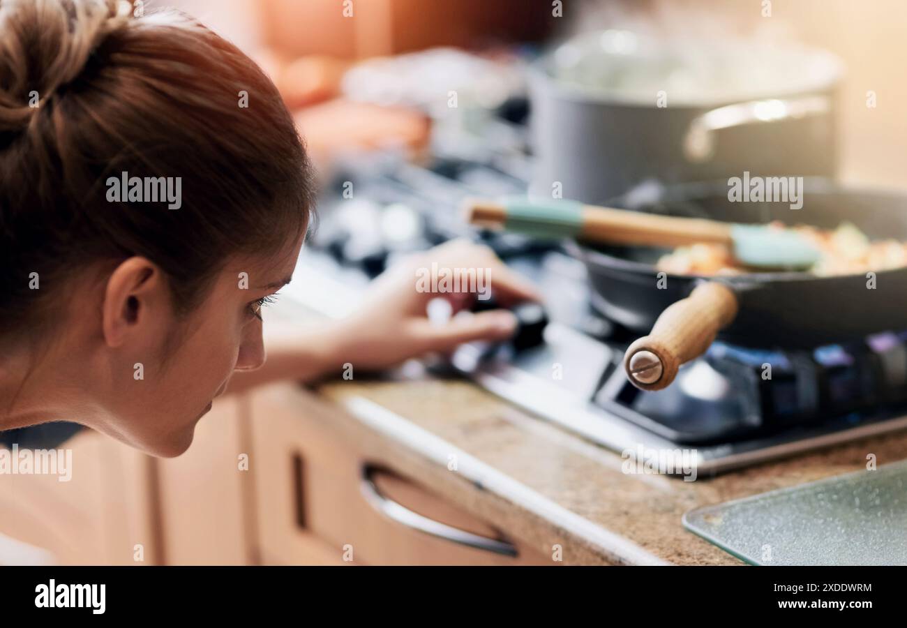 Woman, cooking and check temperature on stove in kitchen with nutrition ...