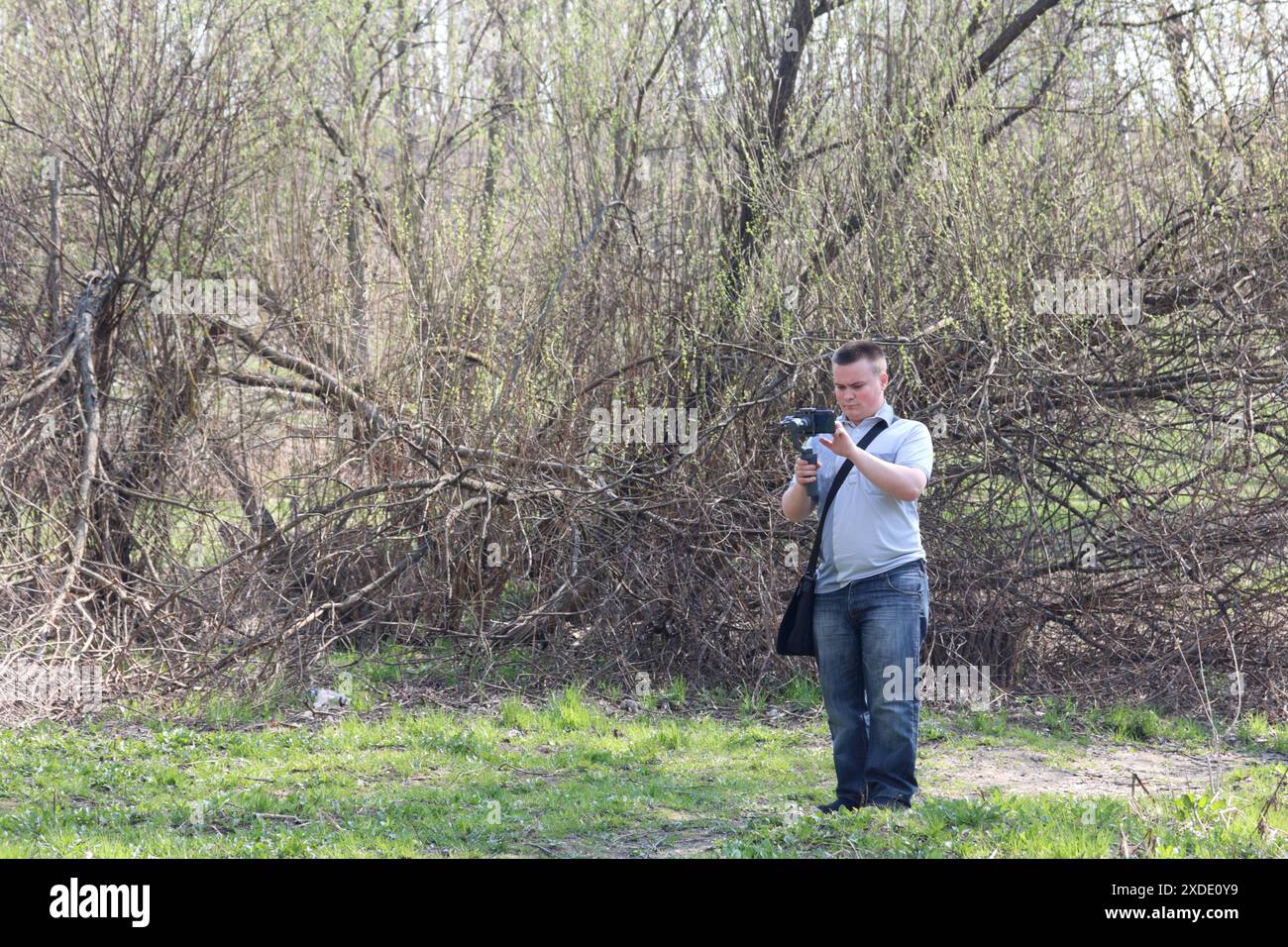 A young man videotaping on a smartphone. Uses gimbal to get smooth ...