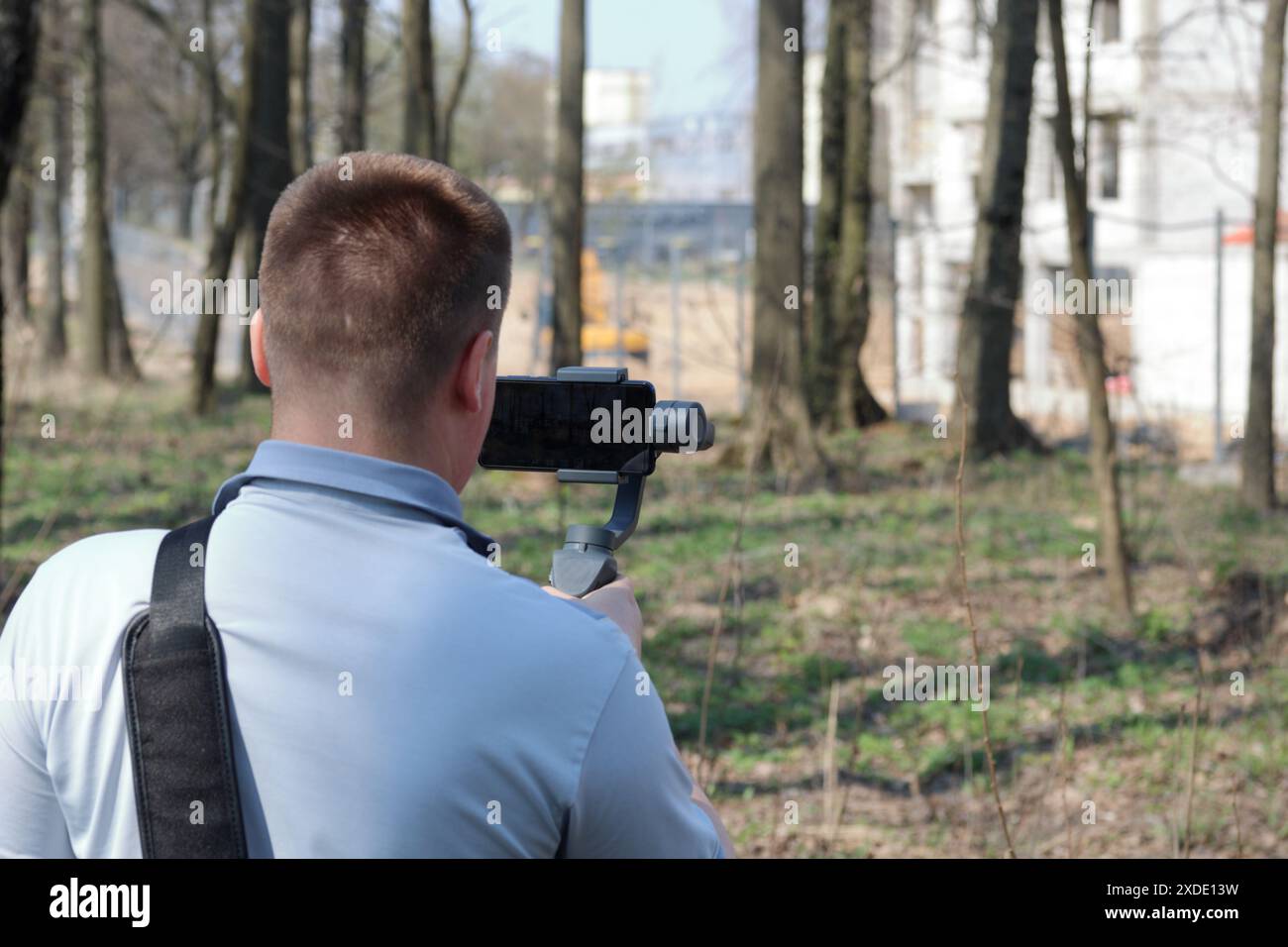 A young man videotaping on a smartphone. Uses gimbal to get smooth ...