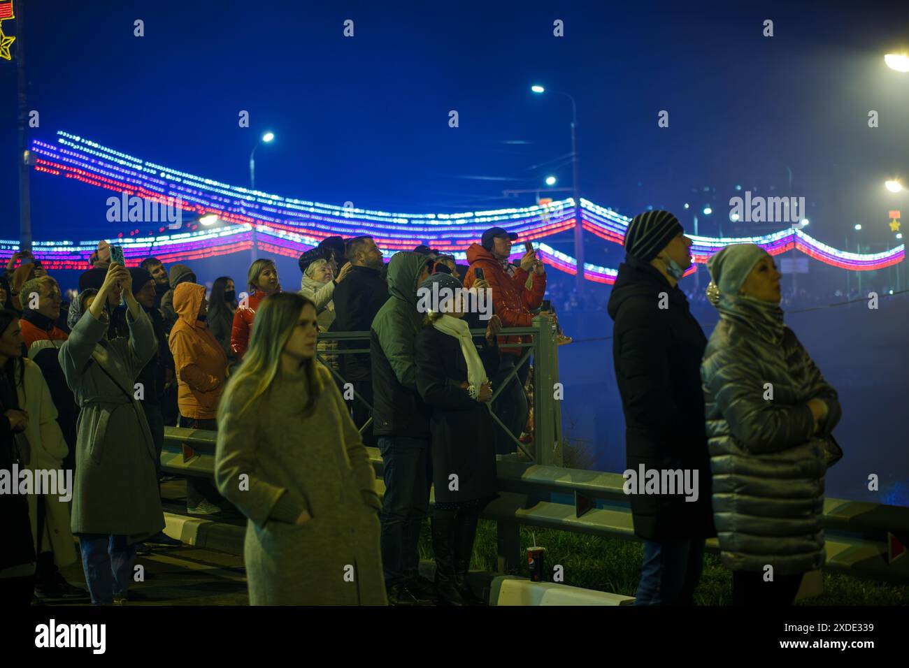crowd of Russian people on the street are watching fireworks in a night ...