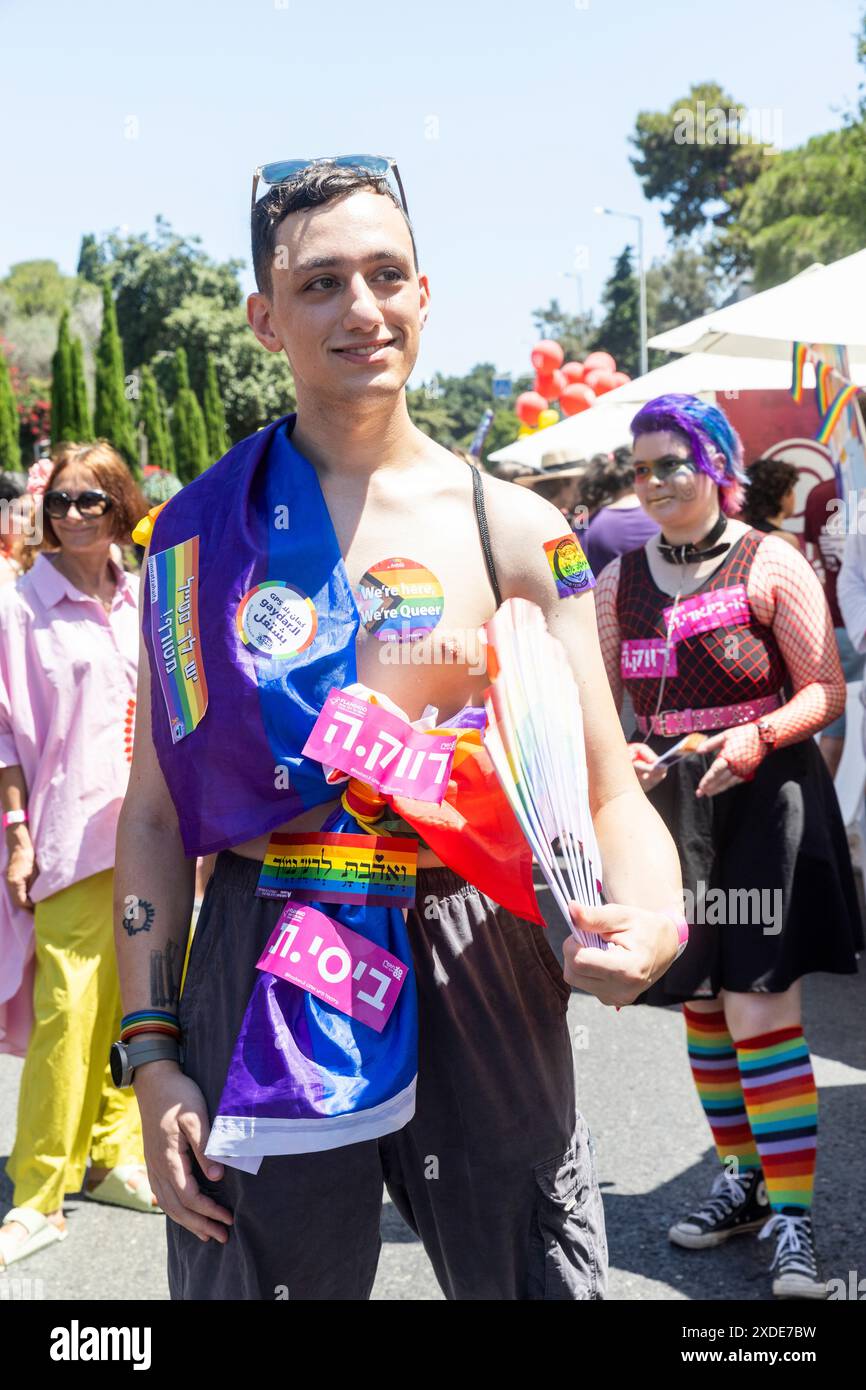 Haifa, Israel June 21, 2024, Young man wearing a rainbow flag with ...