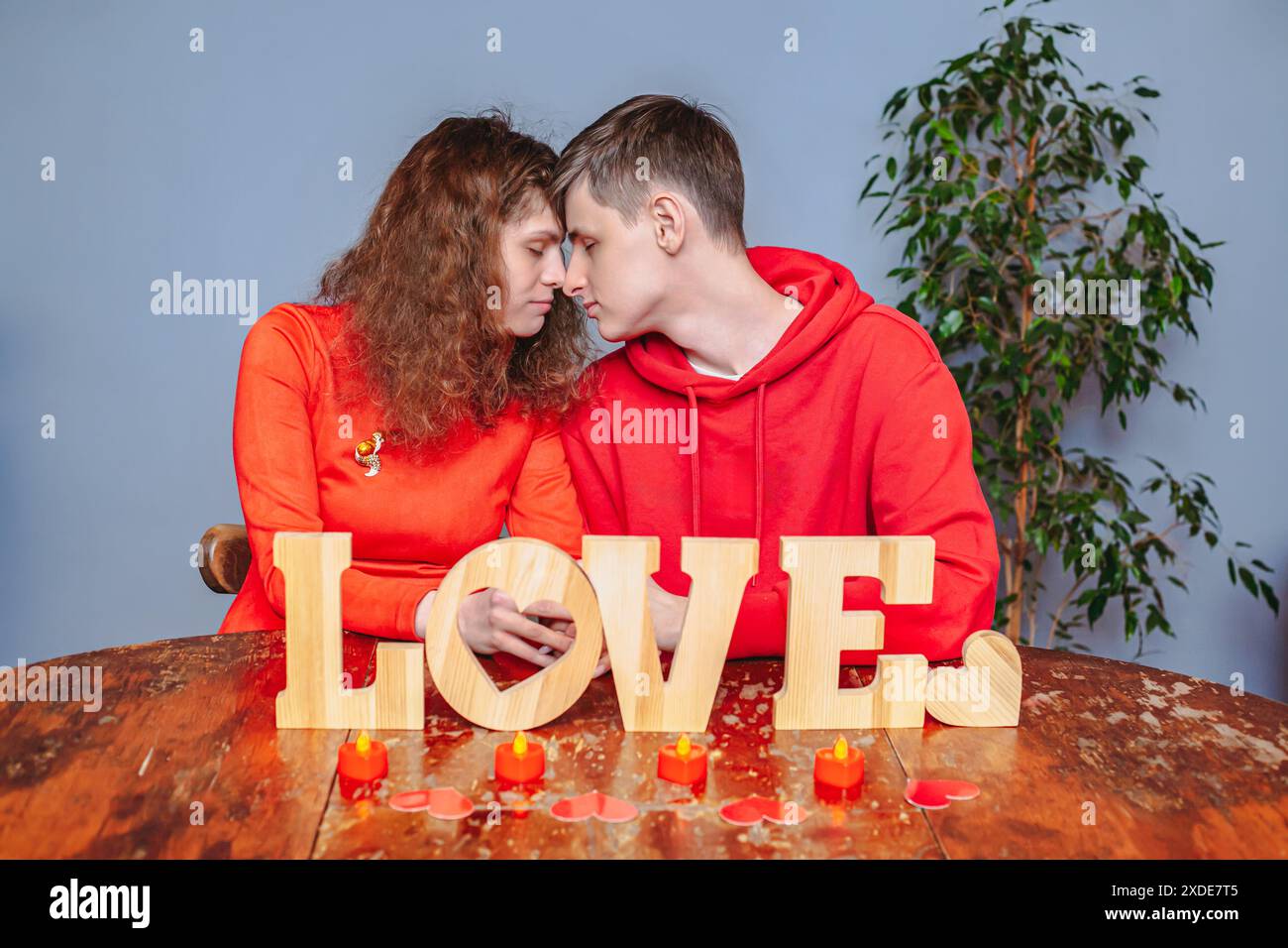 A man and woman are seated at a table, facing each other, in front of a ...