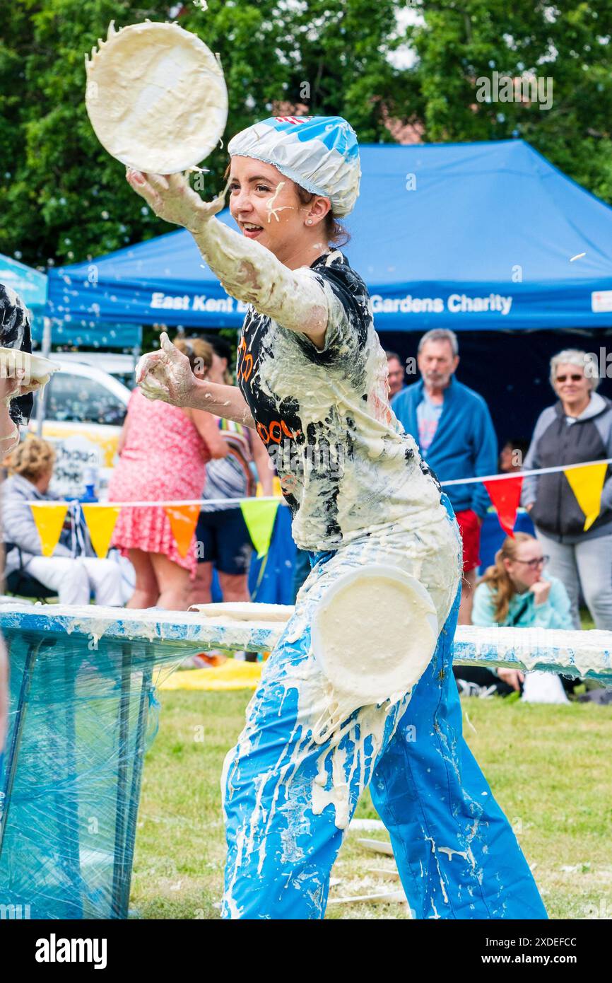Young woman covered in custard throwing a custard pie during the World ...