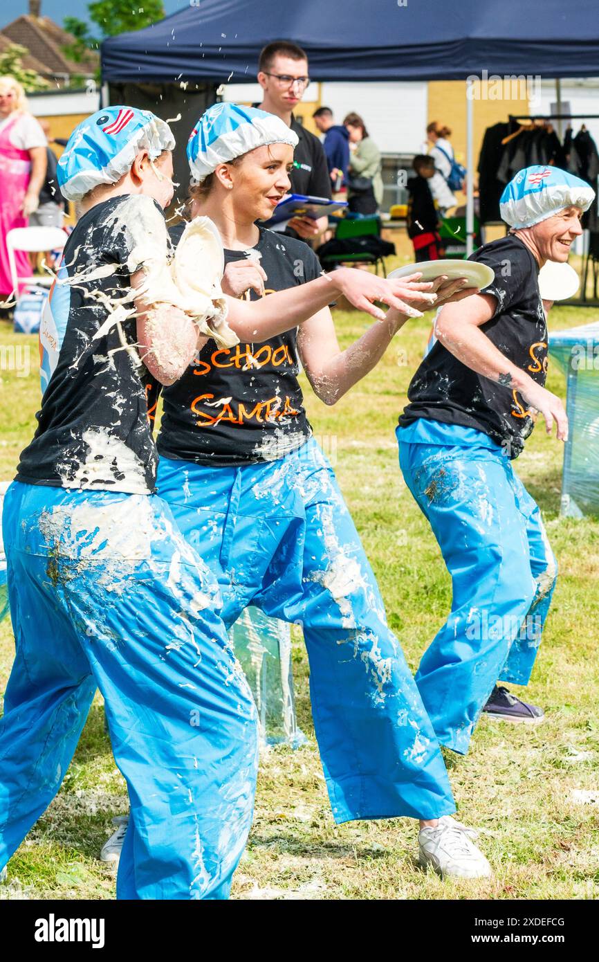 Three woman in a team, two about to hurl custard pies, and the nearest ...