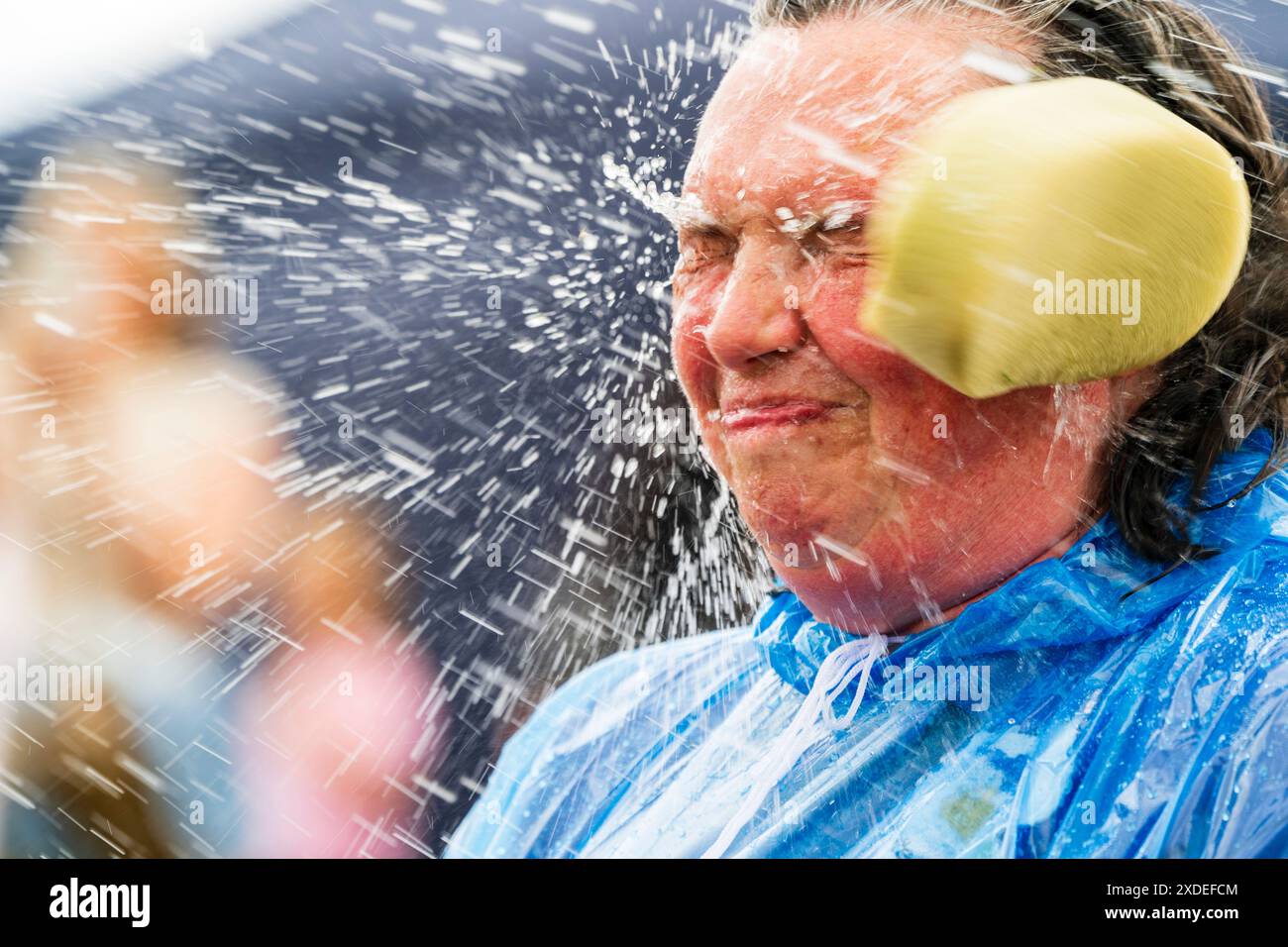 Close up, a woman getting hit directly in the face by a wet sponge ...