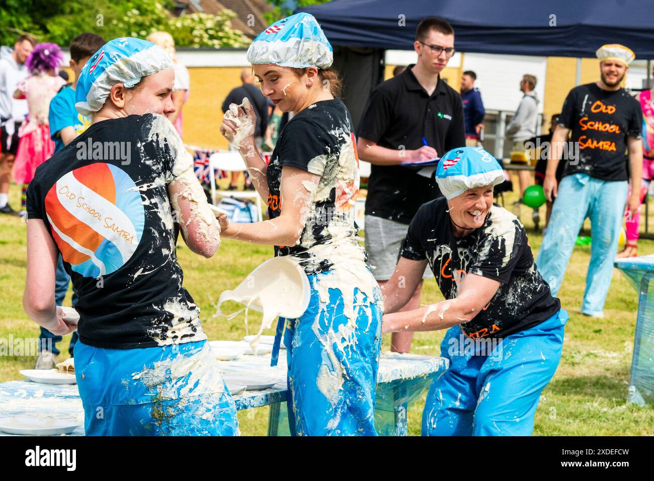 Three women during a custard pie fight, getting hit by pies and about ...