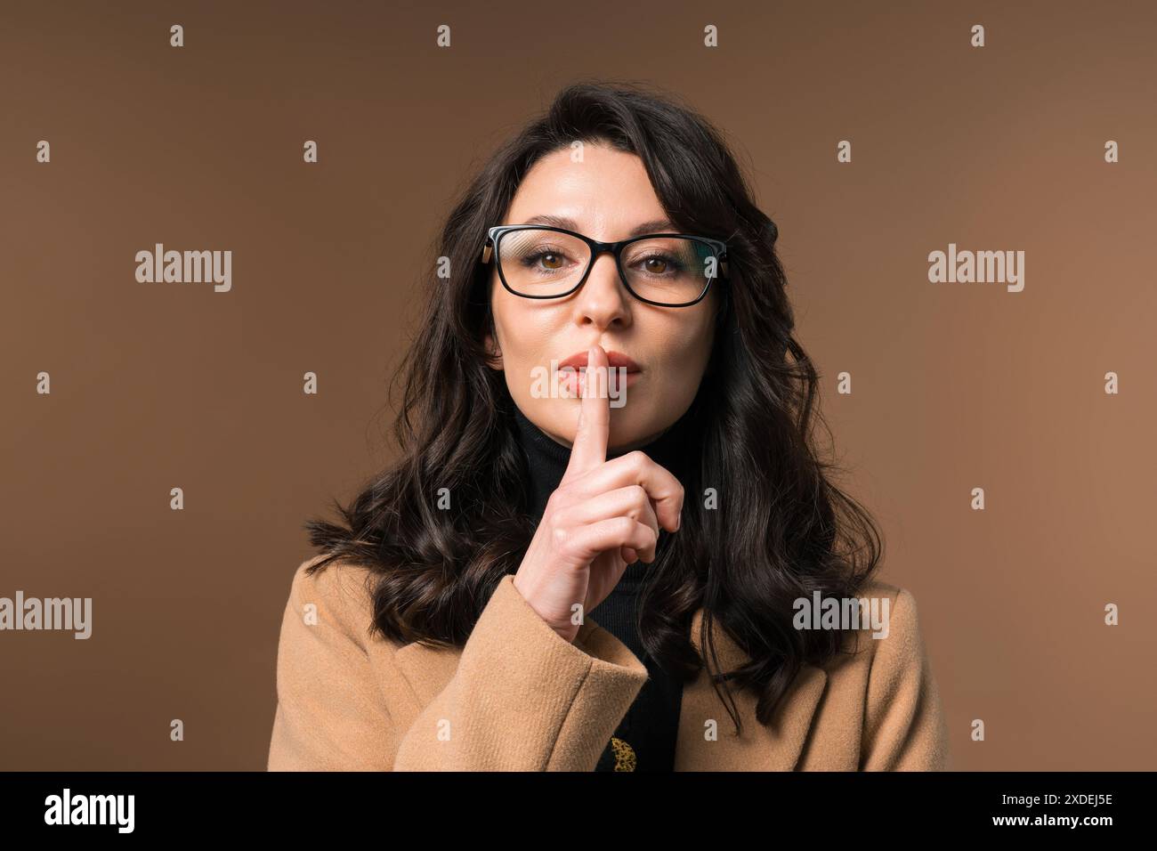 Gossiper businesswoman with finger on lips - shh, secret, silence ...