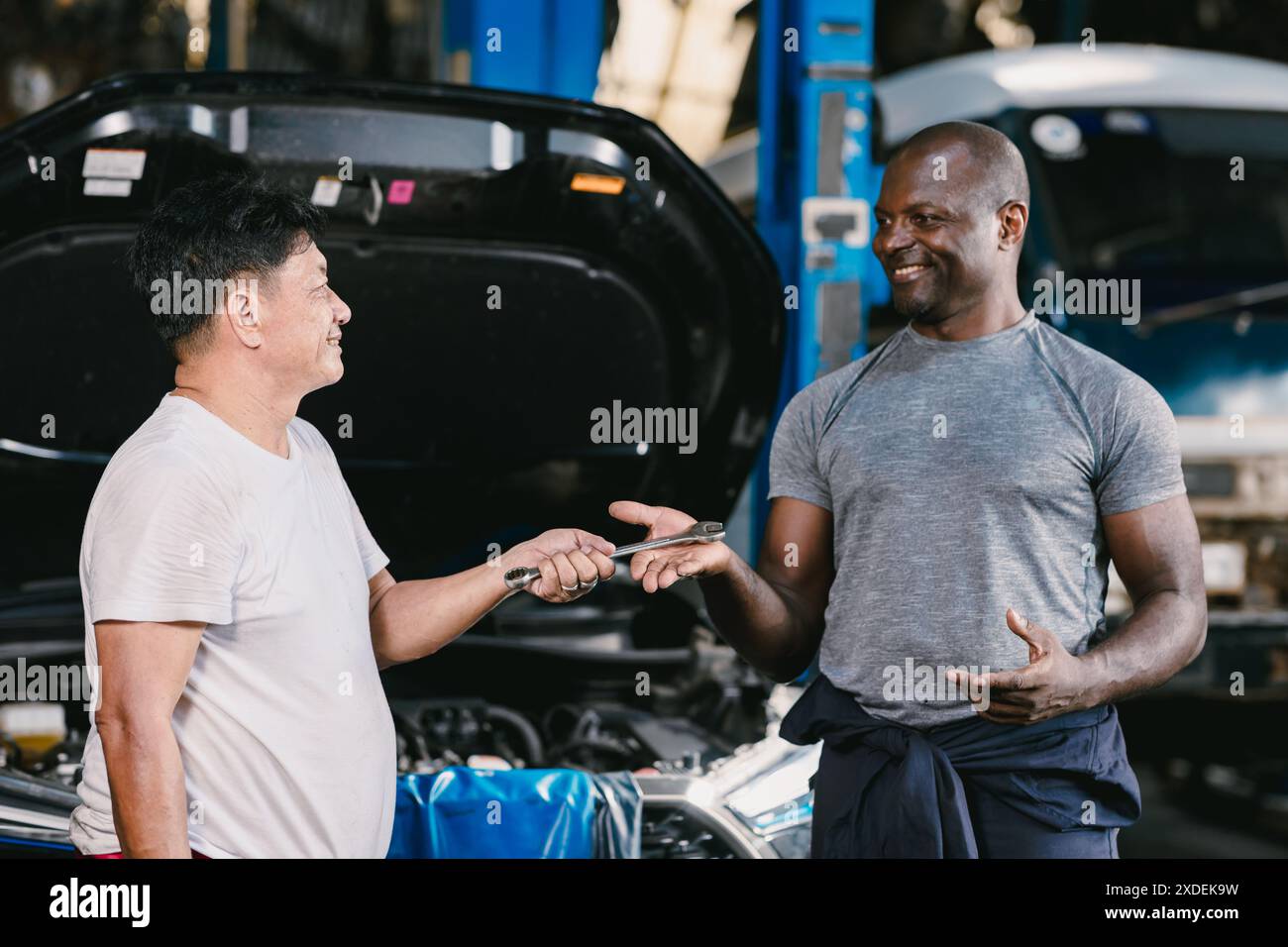 Mechanic team men working together to service fix engine problem in car ...