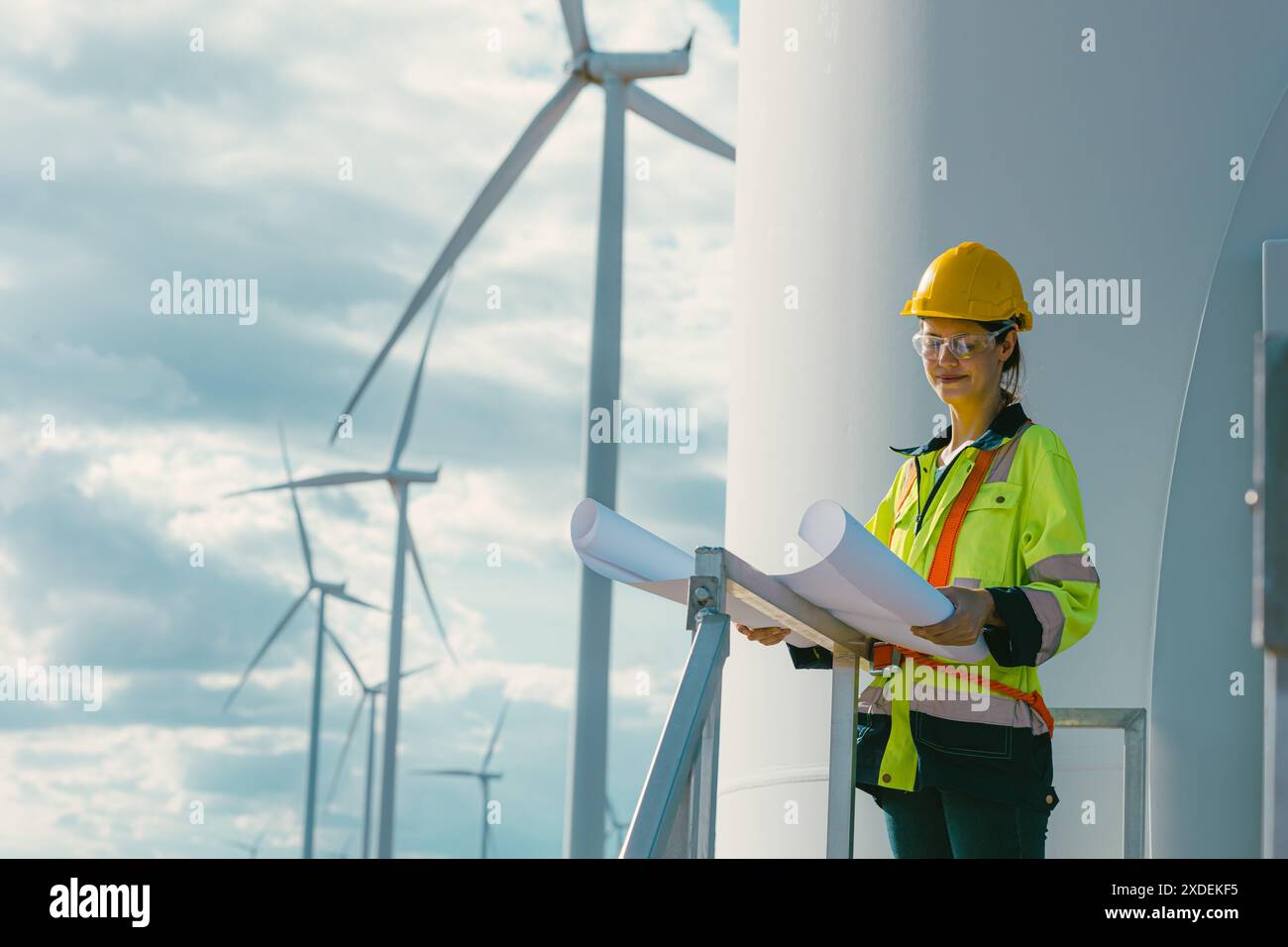 female engineer working outdoor with safety at wind turbines clean ...