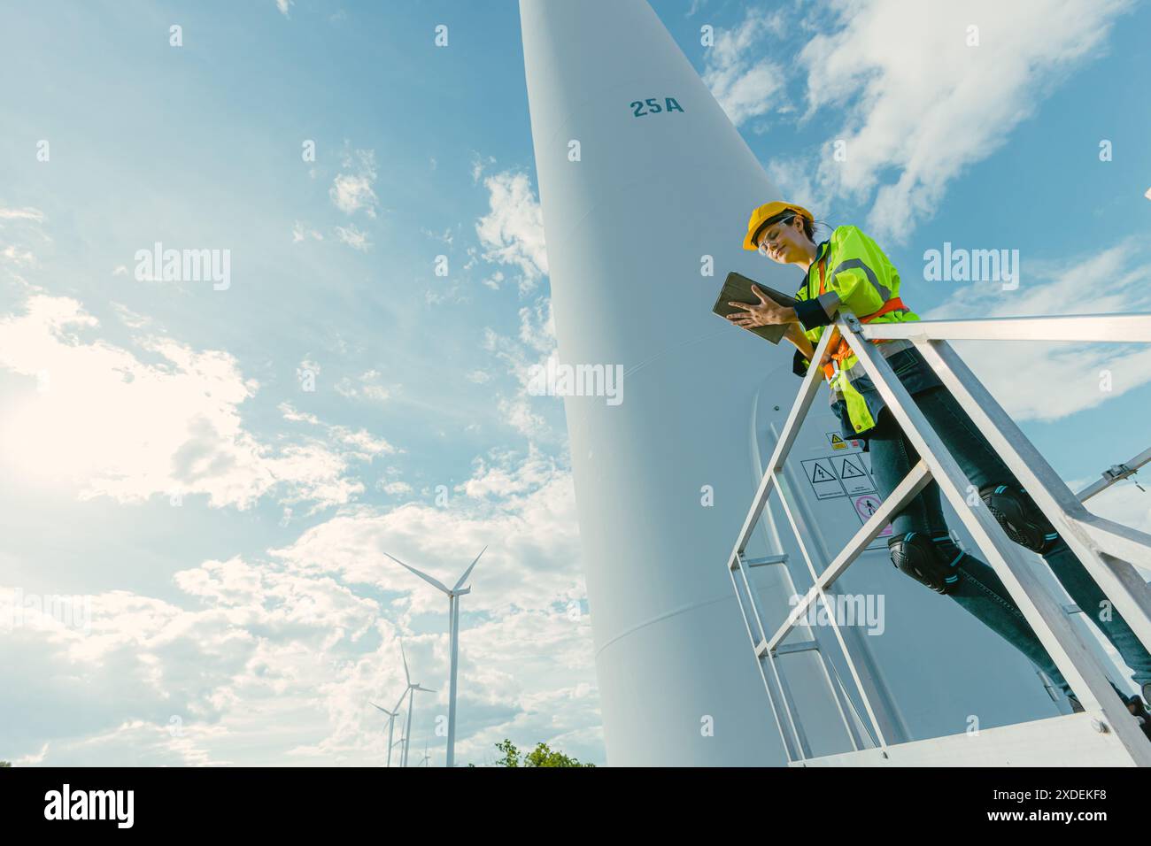 female engineer working outdoor with safety at wind turbines clean ...