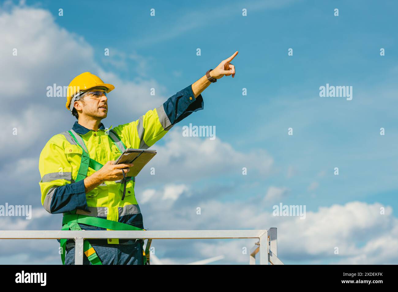 professional engineer male working outdoor with safety at wind turbines ...