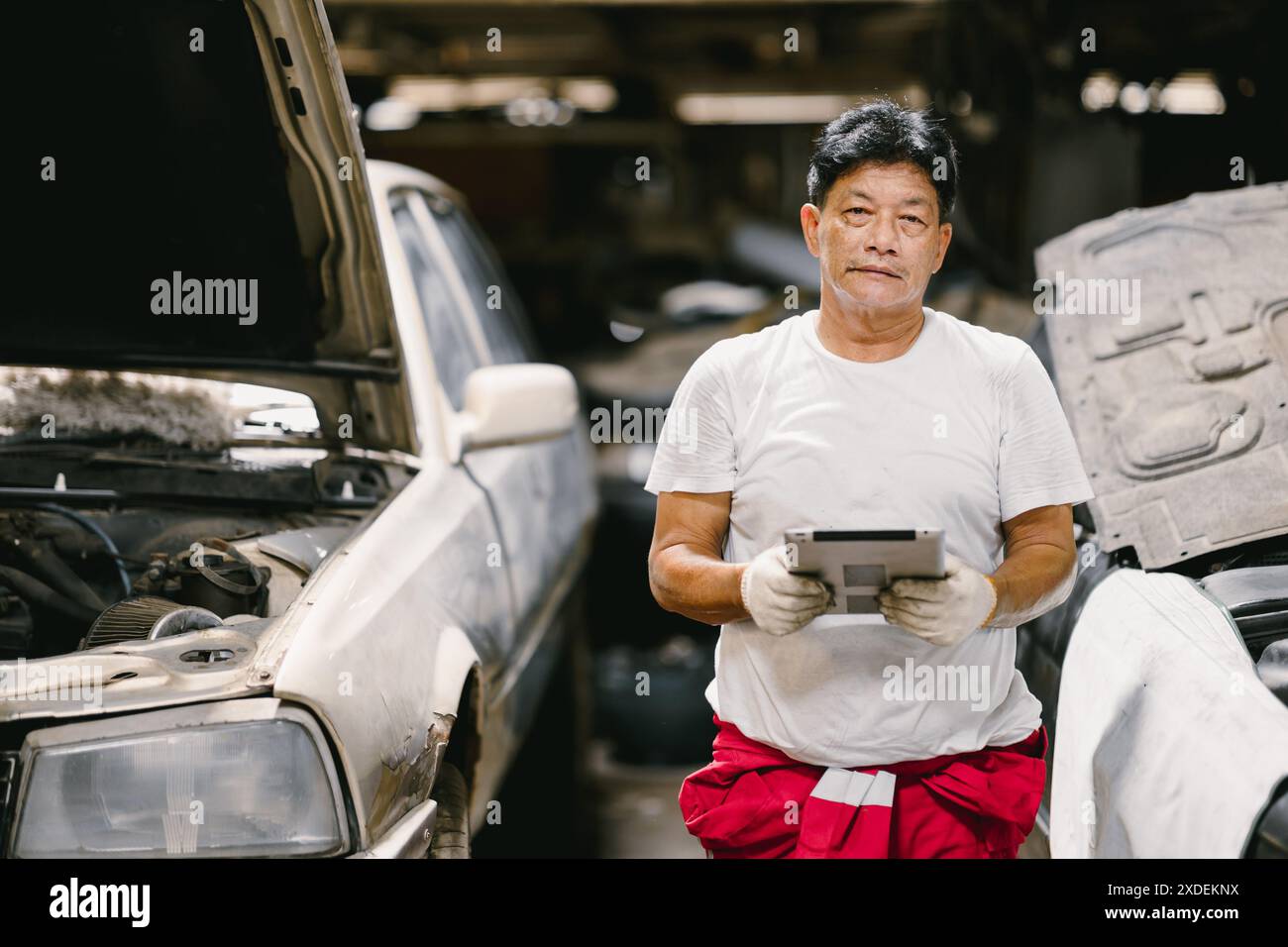 Portrait Auto Mechanic in Garage Car service workshop. Skill male Worker standing with tablet ...