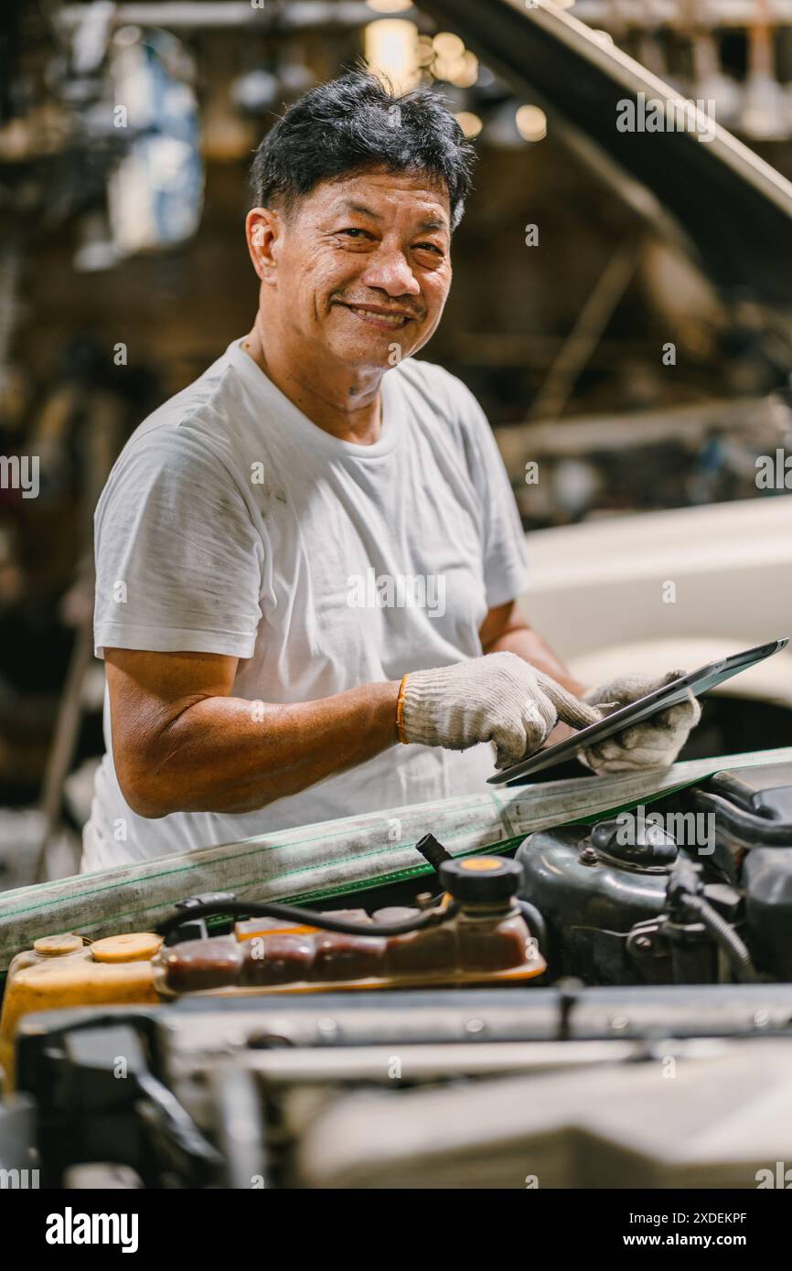 Garage Asian professional working auto service checking engine ...