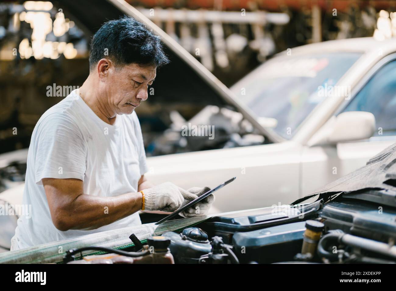 Garage Asian professional working auto service checking engine ...