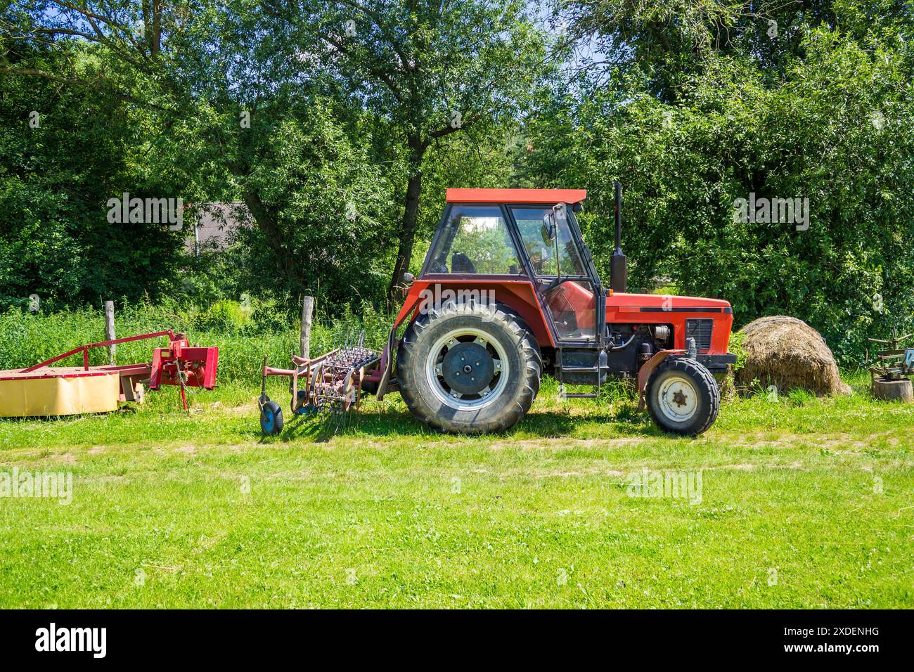 Agricultural machinery in organic farming, red tractor with a plough on ...