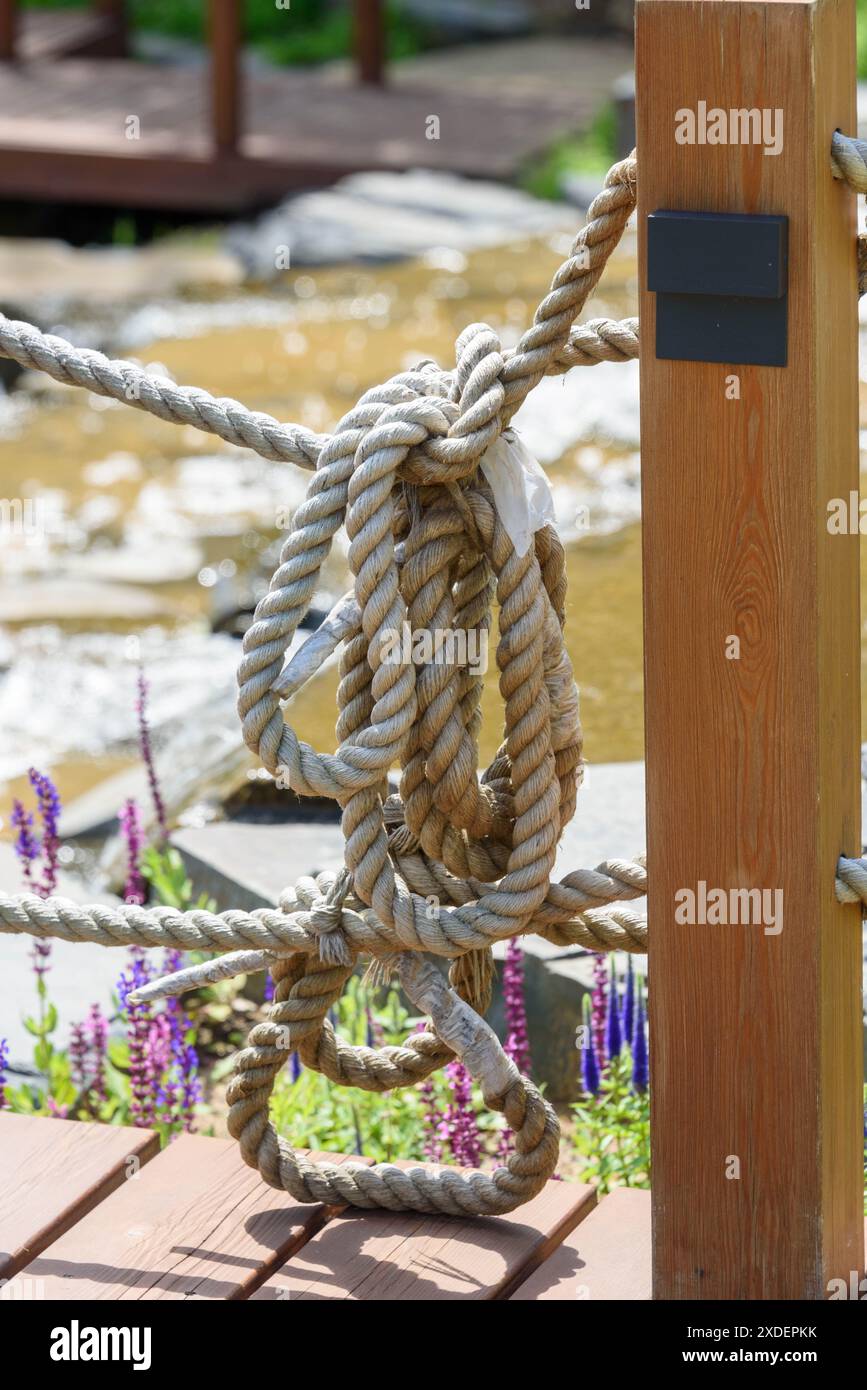 A rope tied to a wooden pole on a pier. A walk through the park Stock ...