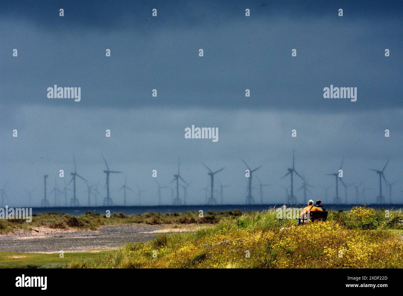 Couple sitting looking out to sea on Haverigg Beach near Millom UK with ...