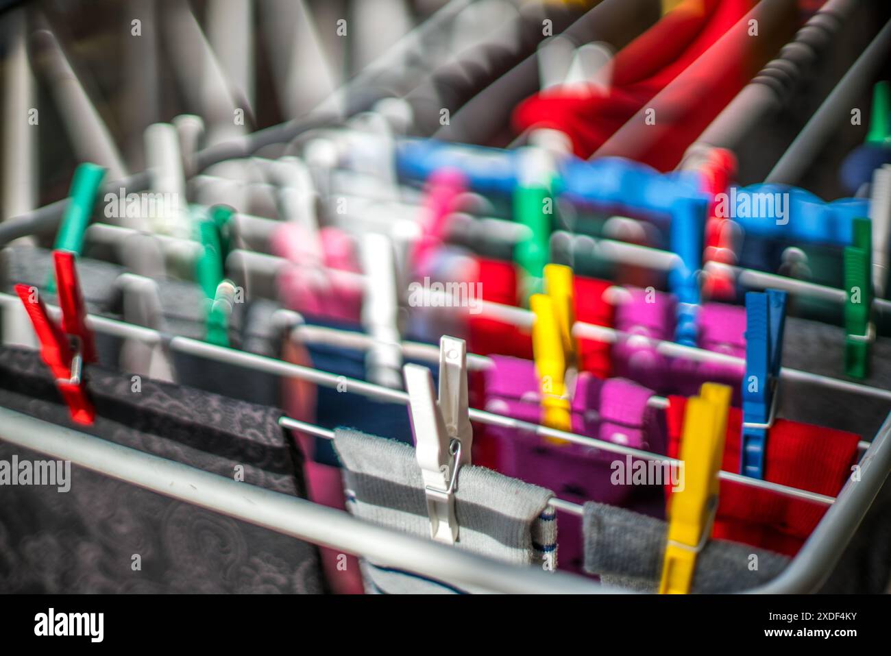 Close-up of colorful clothespins securing various clothing items on a ...