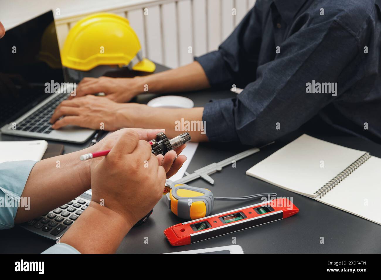 The engineering team point to the gear and discussing on their project ...